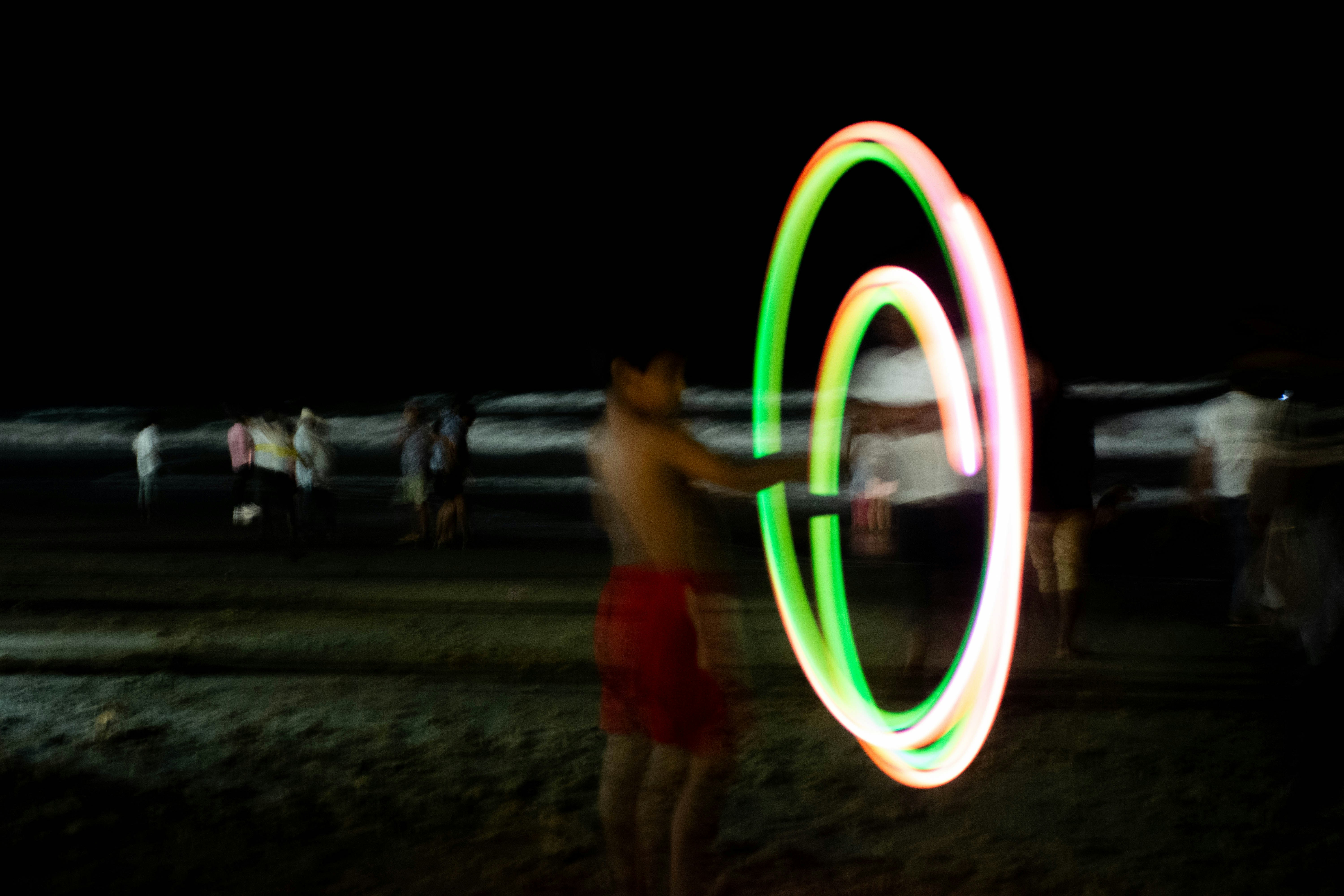 Neon Hoop Dancer on a Moonlit Beach