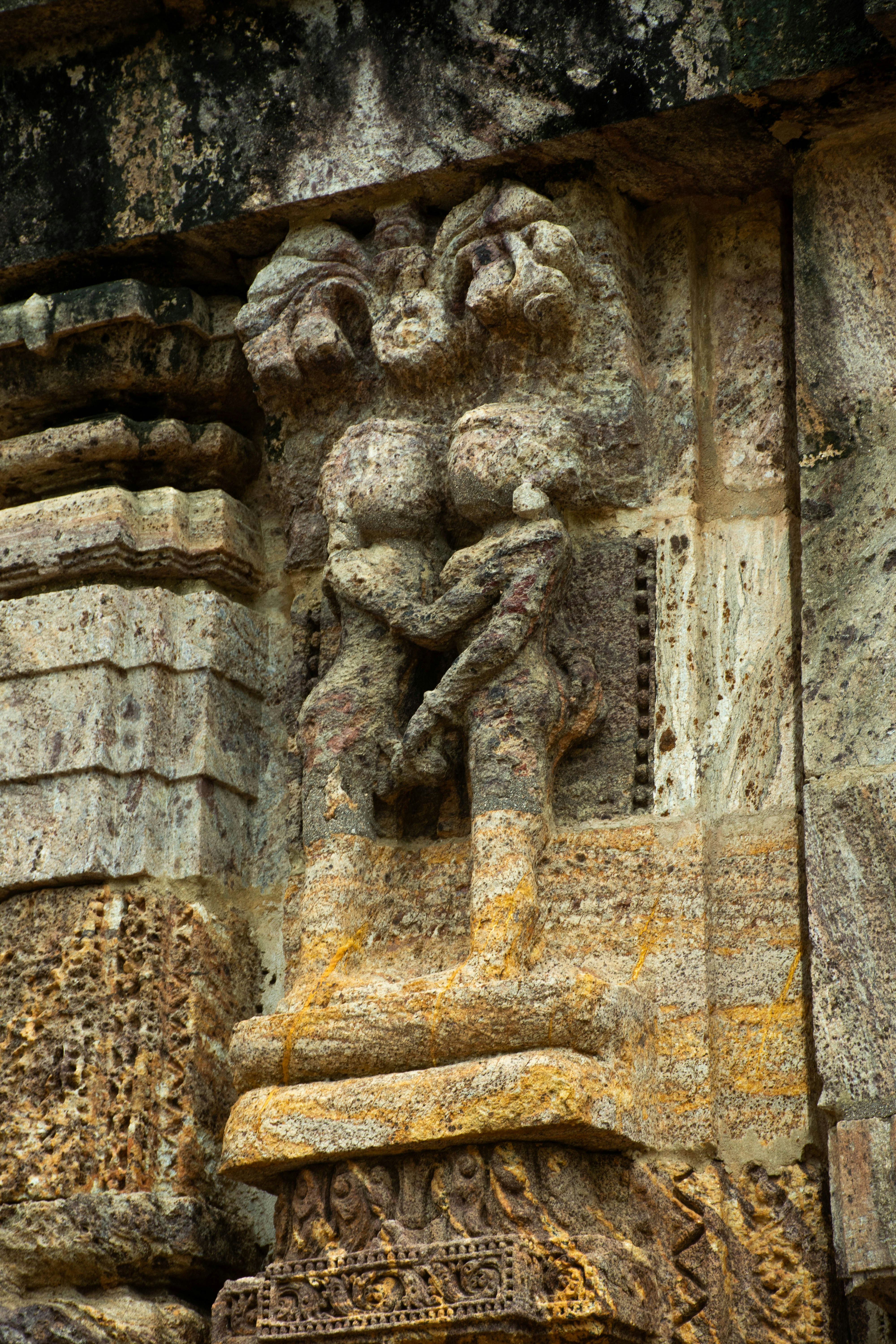 Intricately carved stone sculpture depicting a mythical creature, showcasing detailed craftsmanship on a temple wall.