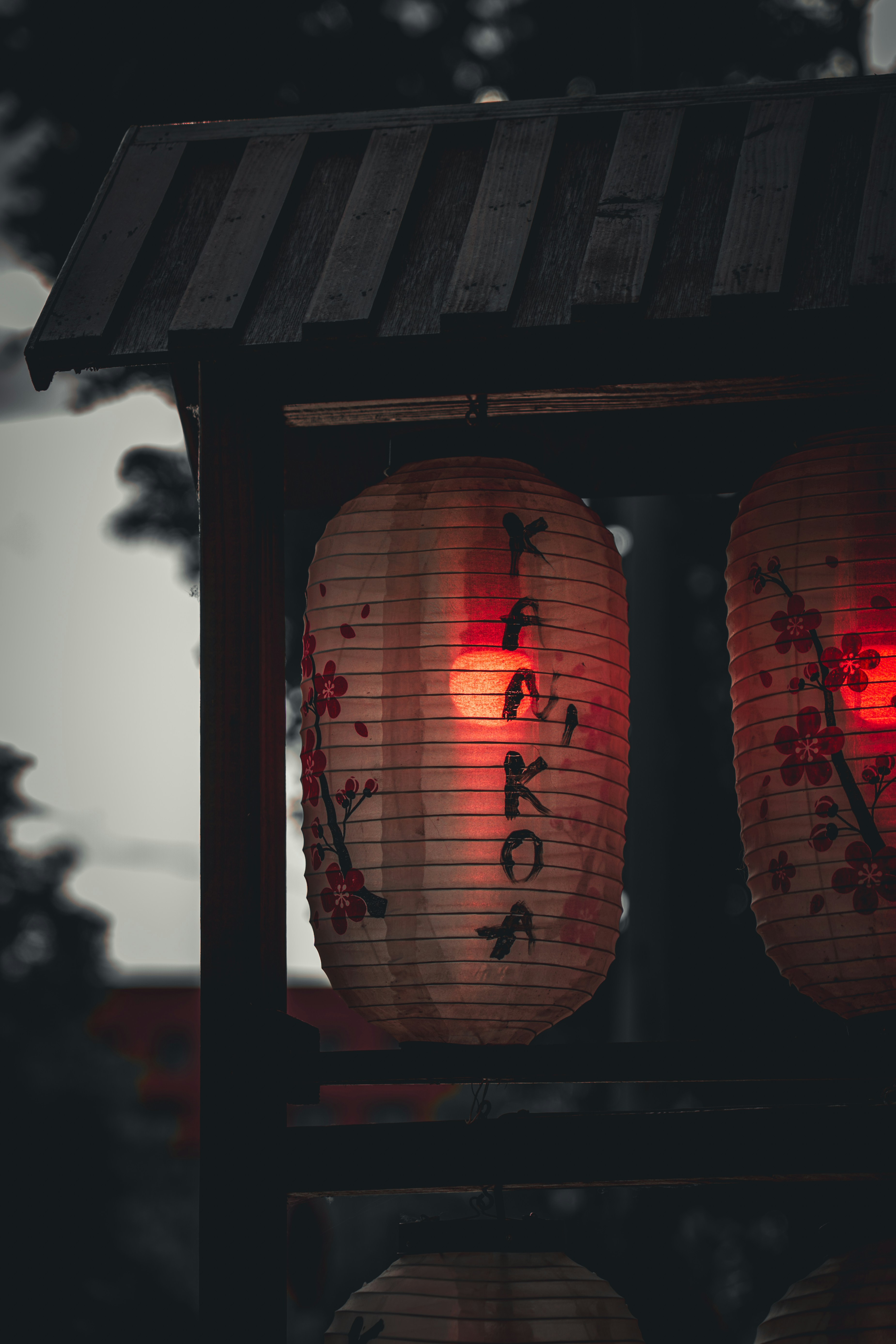 Red Lanterns Framed by Timber at Dusk