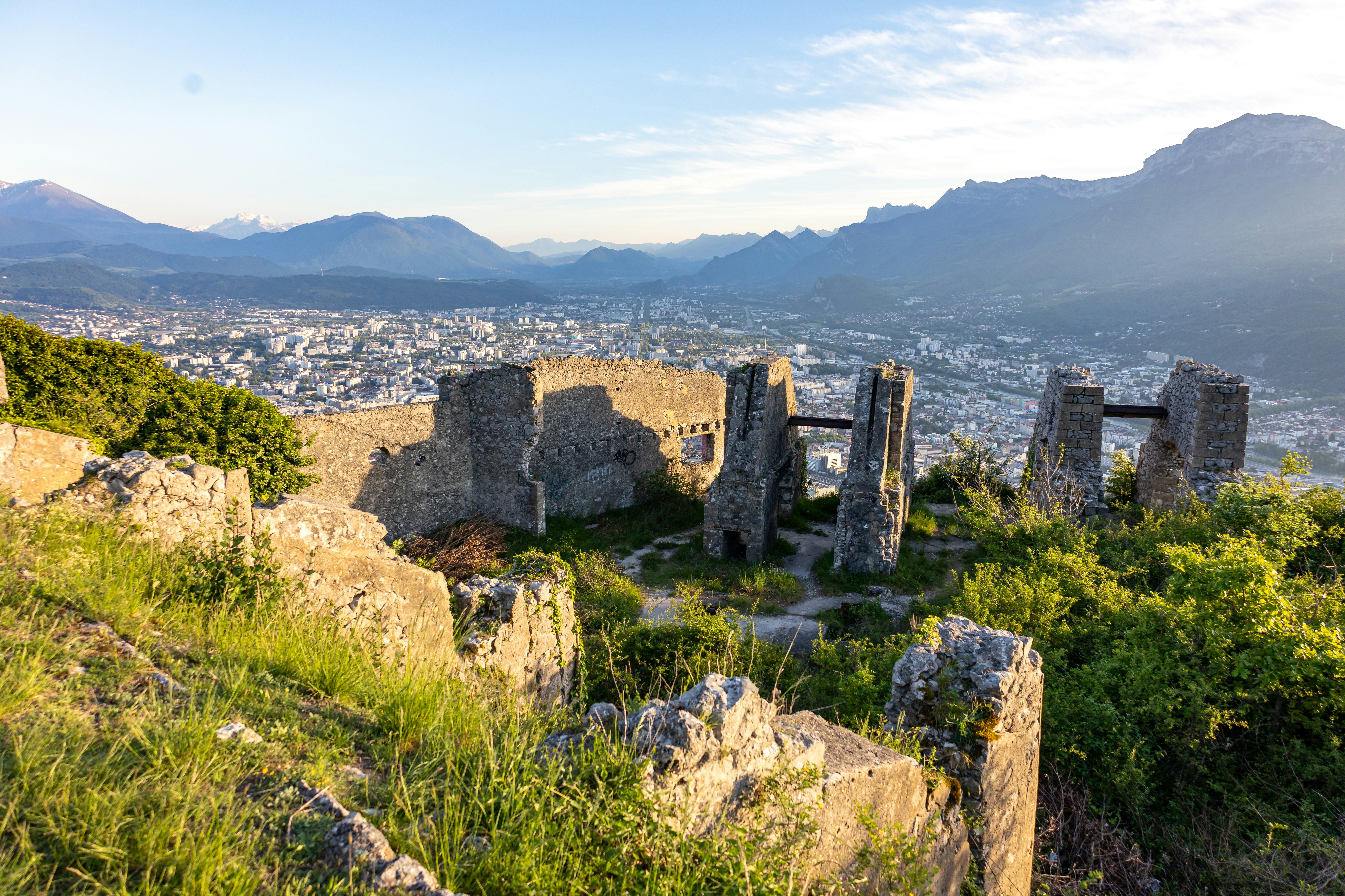 Stone Sentinels Over a Valley City Beneath Mountain Peaks