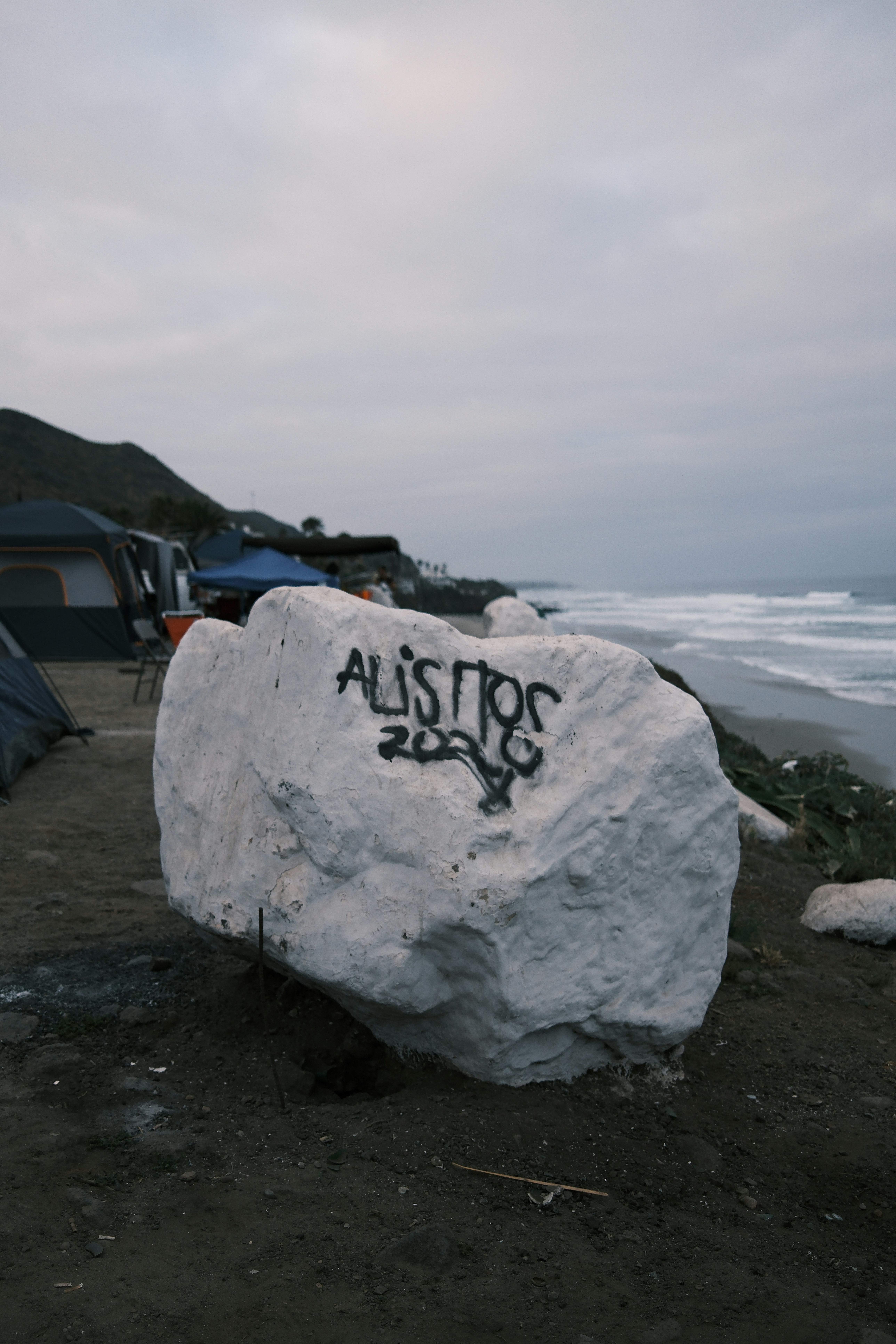 Graffiti Rock Guarding a Seaside Campground at Dusk