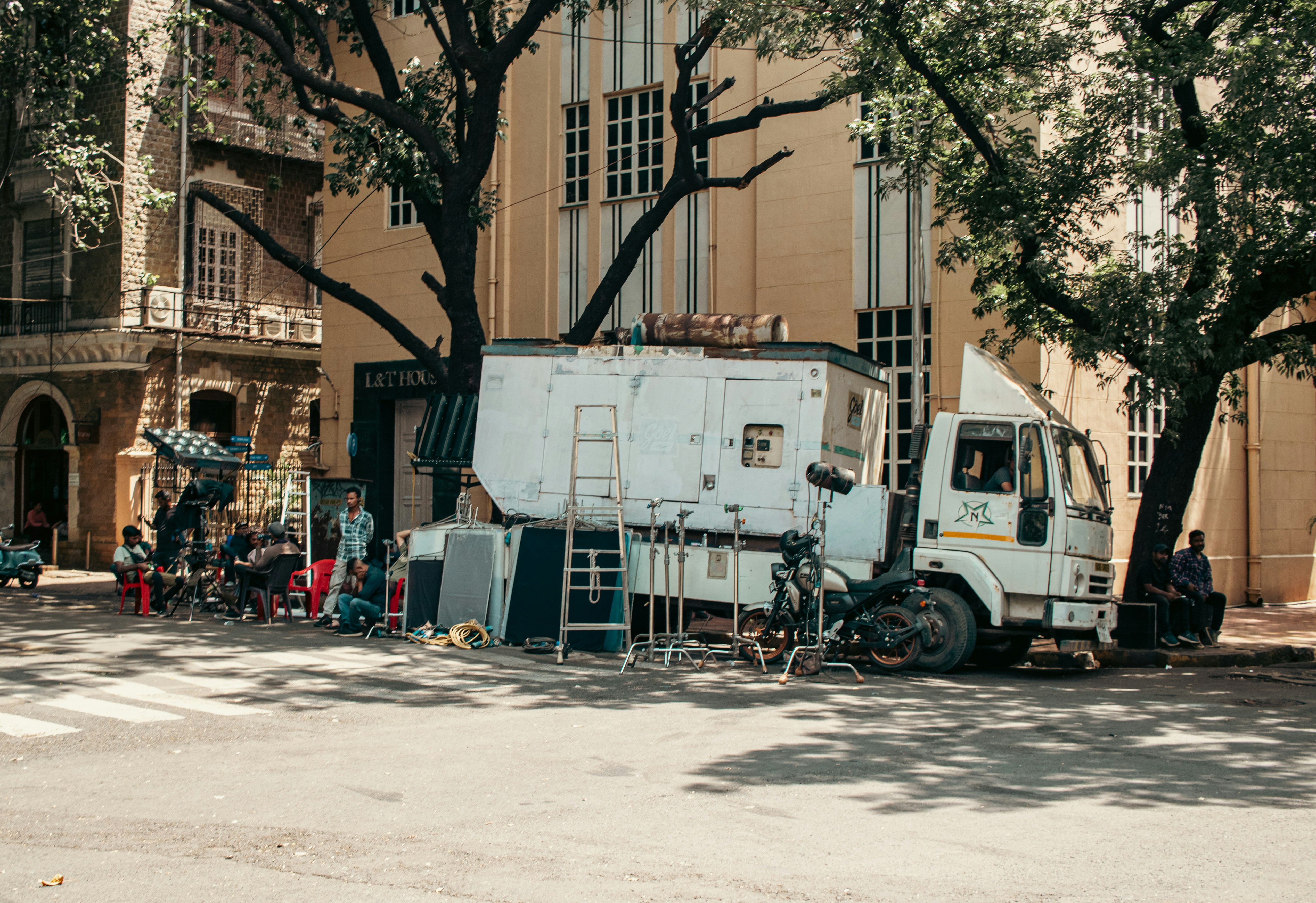A film production unit's equipment is captured in this photo | A truck with equipment parked by a building.