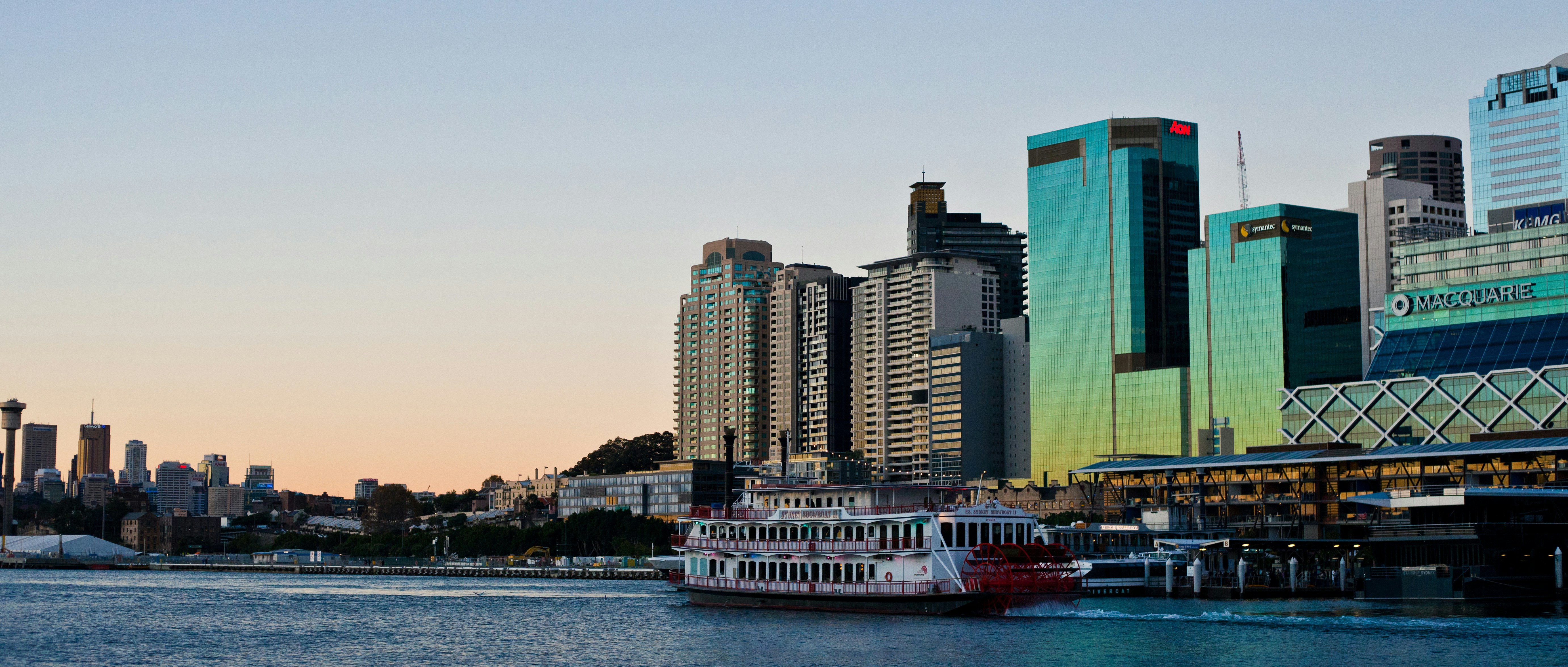 Crimson Steamer at Sundown: A Harbor Portrait of Water and Turquoise Glass Towers