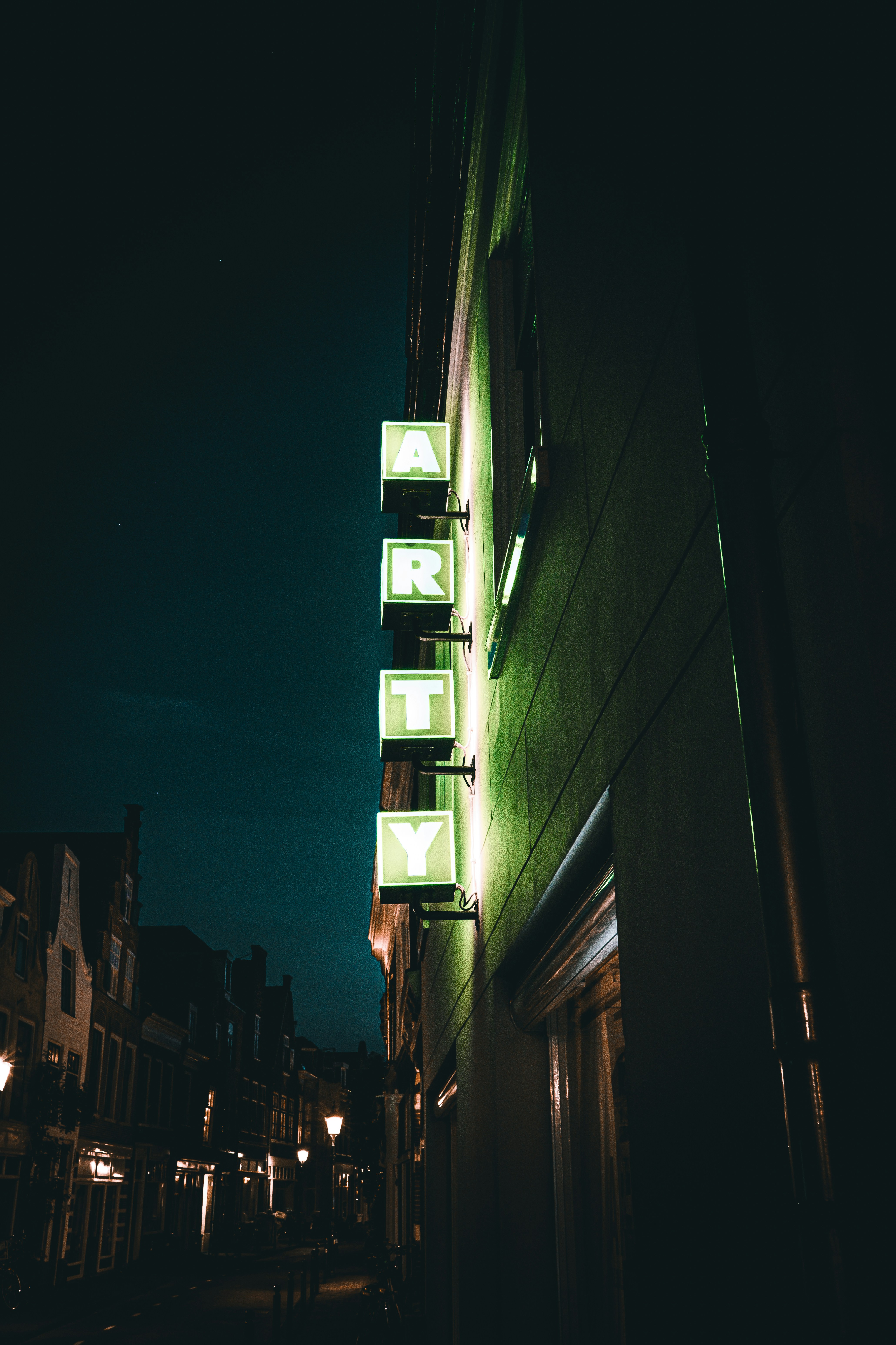 "arty" neon sign lights up a dark street. photo – Free Building Image ...