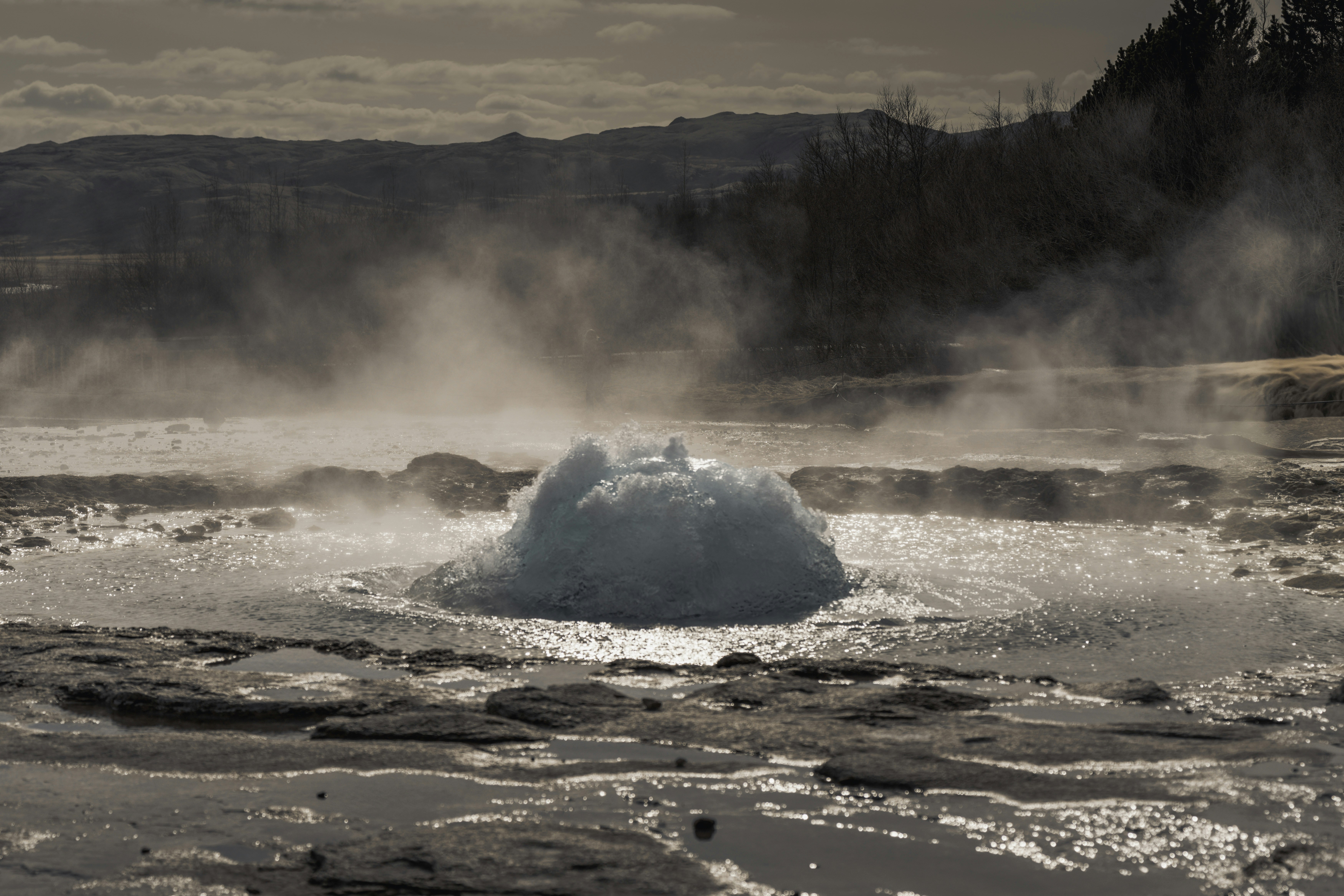 Blue Ice Eruption: Steam and Silhouette Over a Geyser Rim