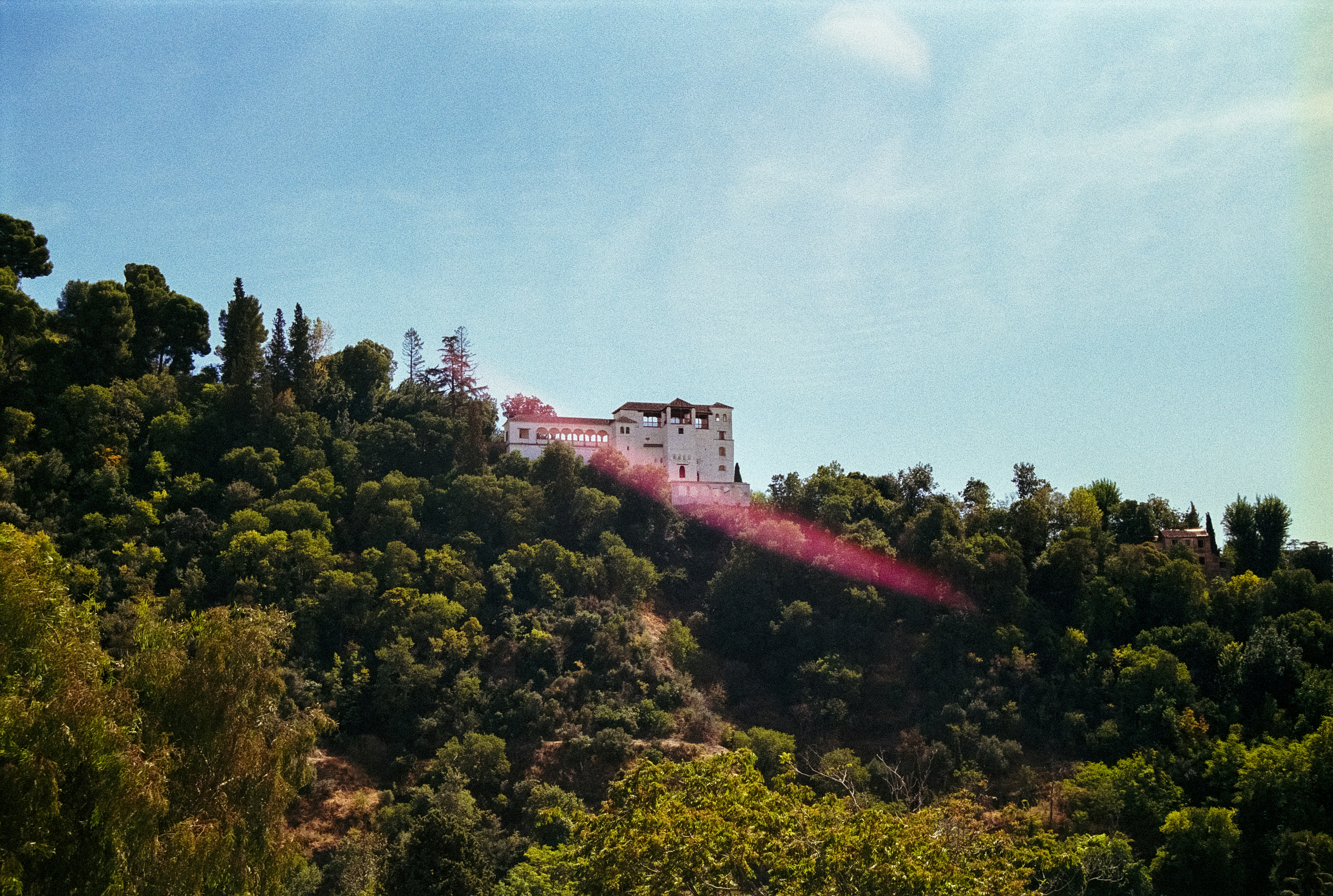 Hilltop Castle Above a Verdant Ridge Beneath a Bright Sky