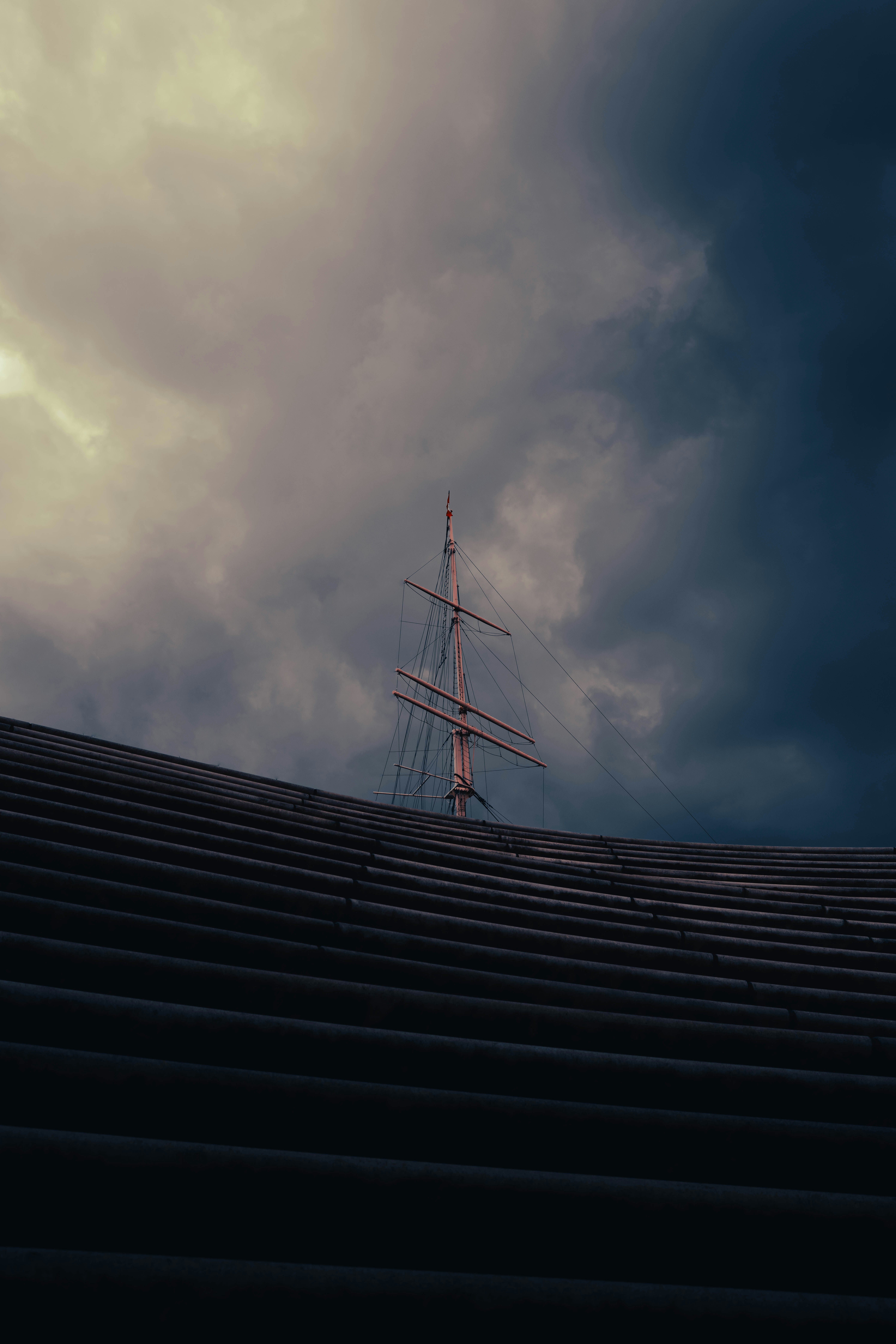 The Silent Watcher: A Ship's Mast Against the Stormy Sky