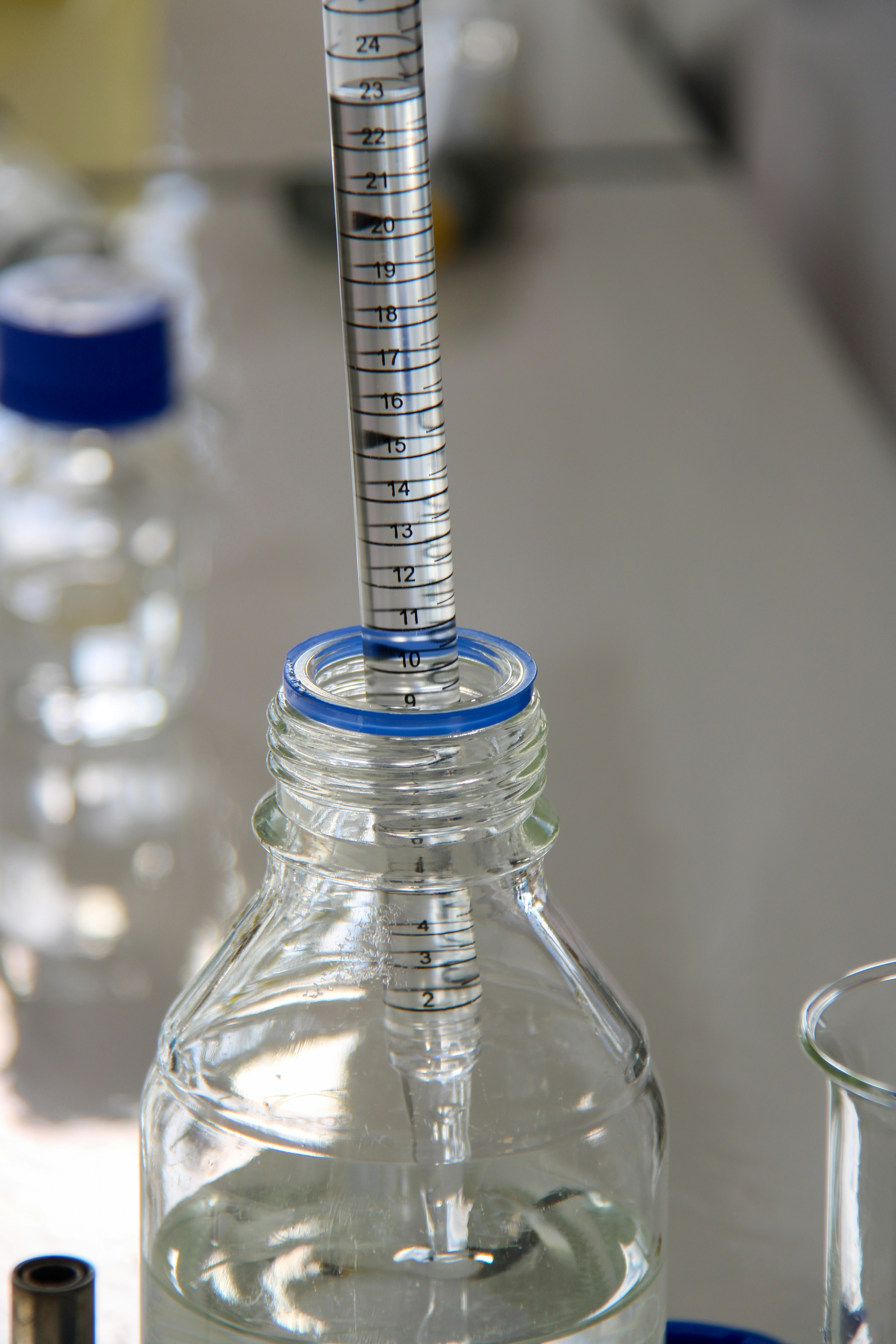 A pipette is dispensing liquid into a glass bottle. photo – Free Medicine Image on Unsplash