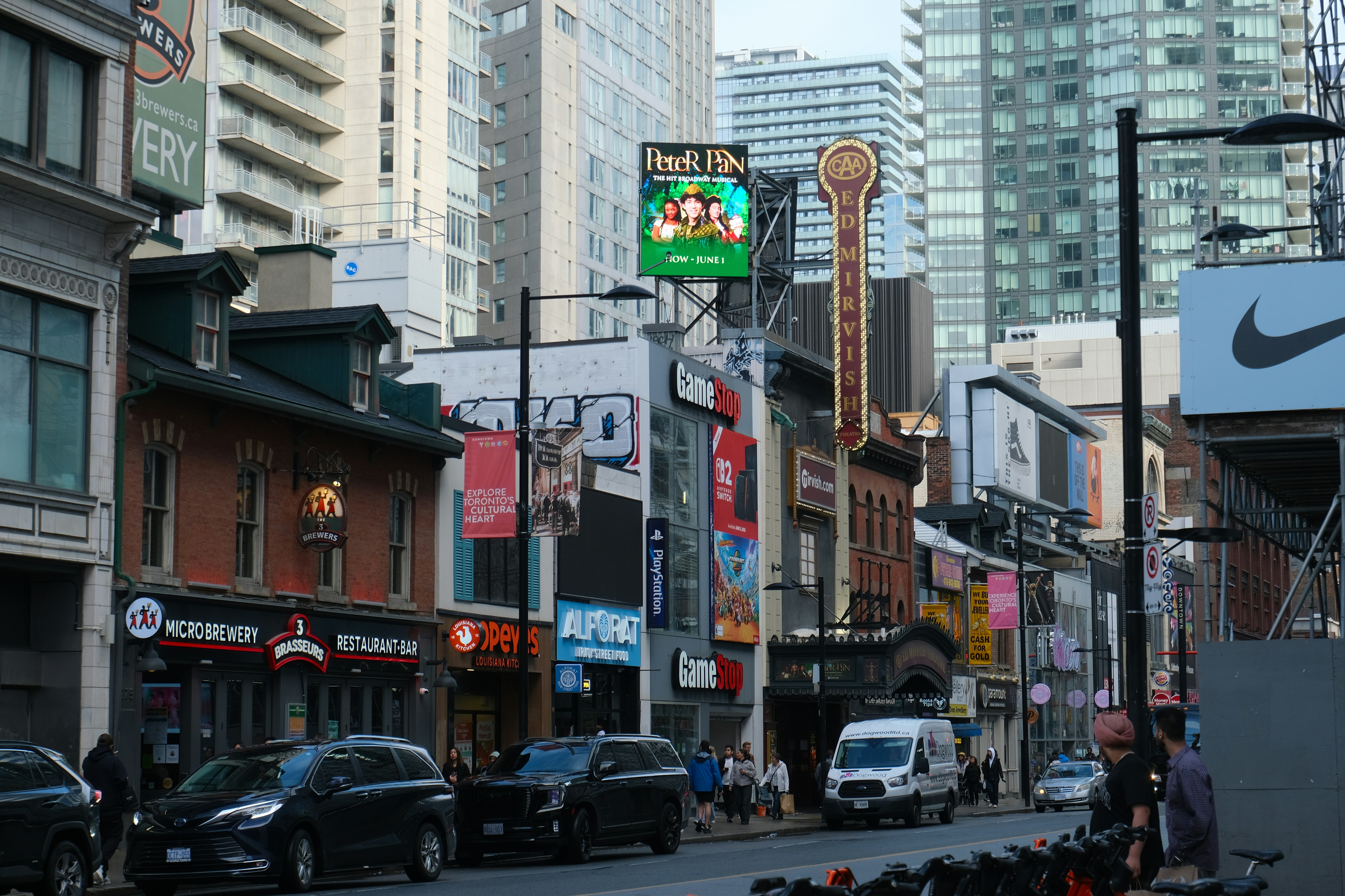 Neon Crossroads: Nike Swoosh Dominates a Bustling Downtown Block