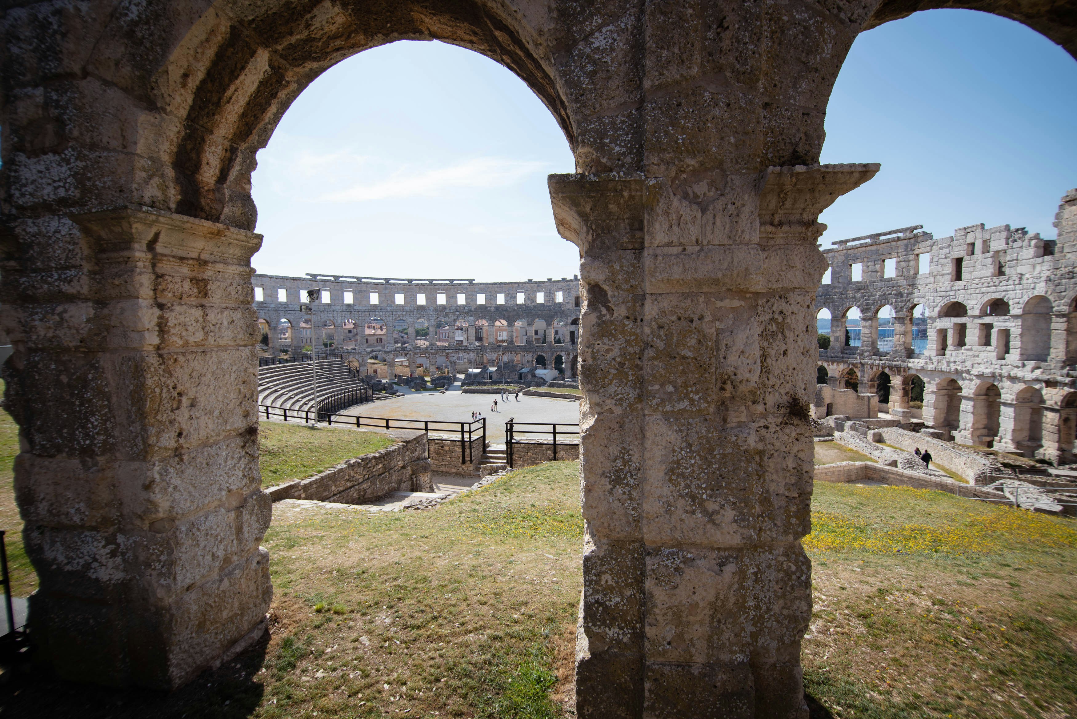 Foto Pemandangan arena romawi melalui lengkungan batu. – Gambar Konser ...