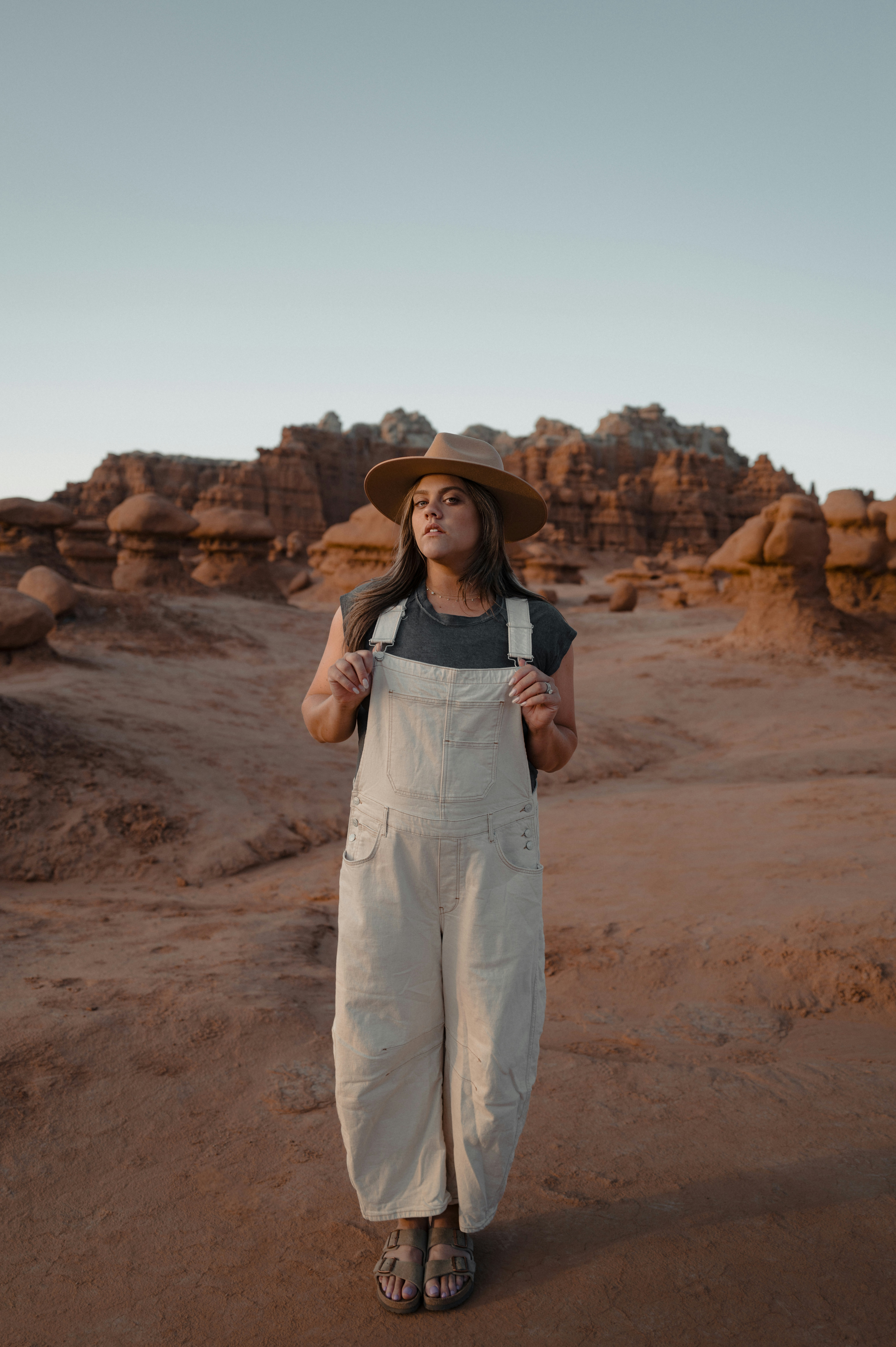 A woman in overalls poses in a desert landscape. photo – Free Woman ...
