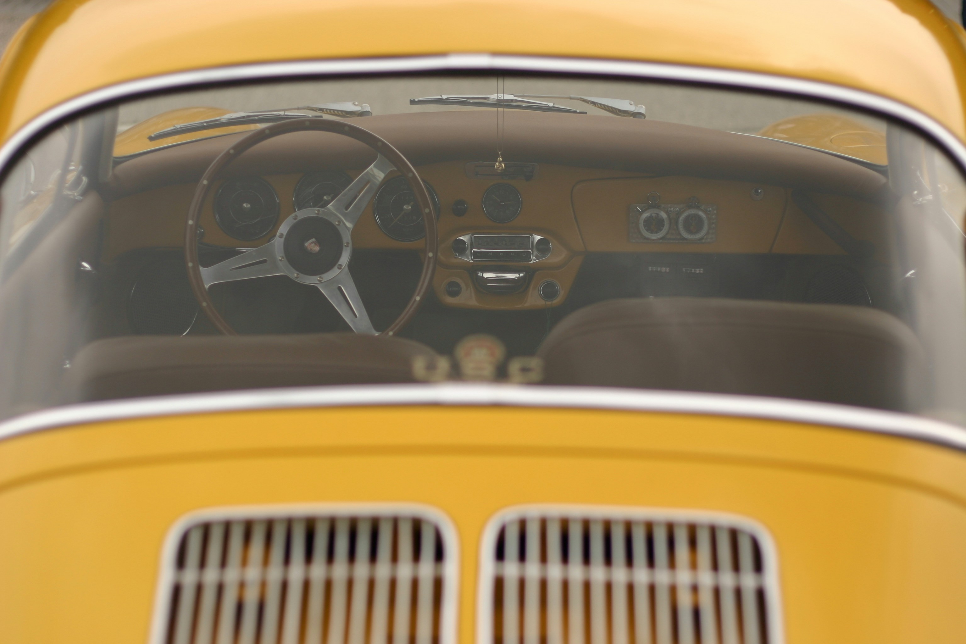 Amber Nostalgia: The Classic Car's Cockpit Through a Yellow Rear Window