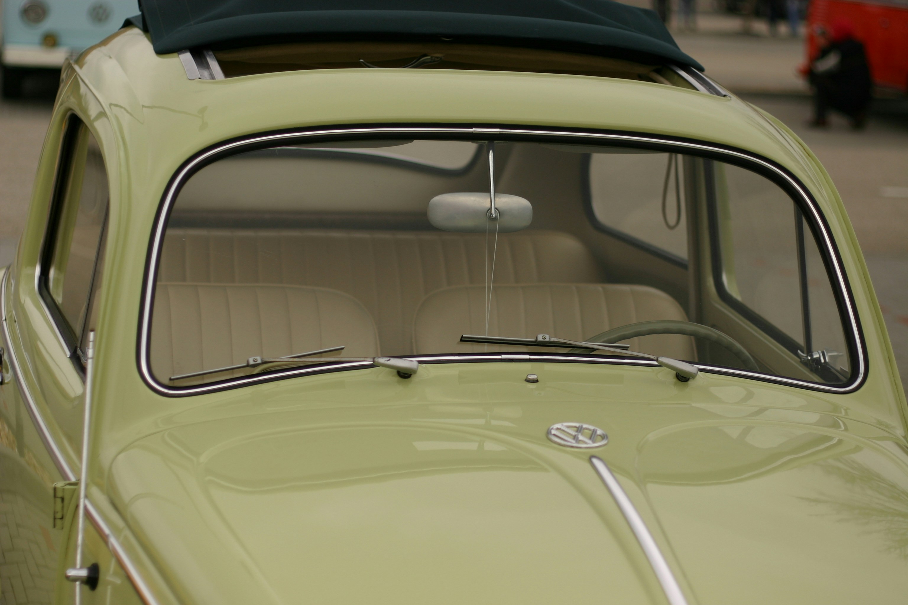 Interior view of a vintage Volkswagen, showcasing its retro design with beige seats and distinctive dashboard features.