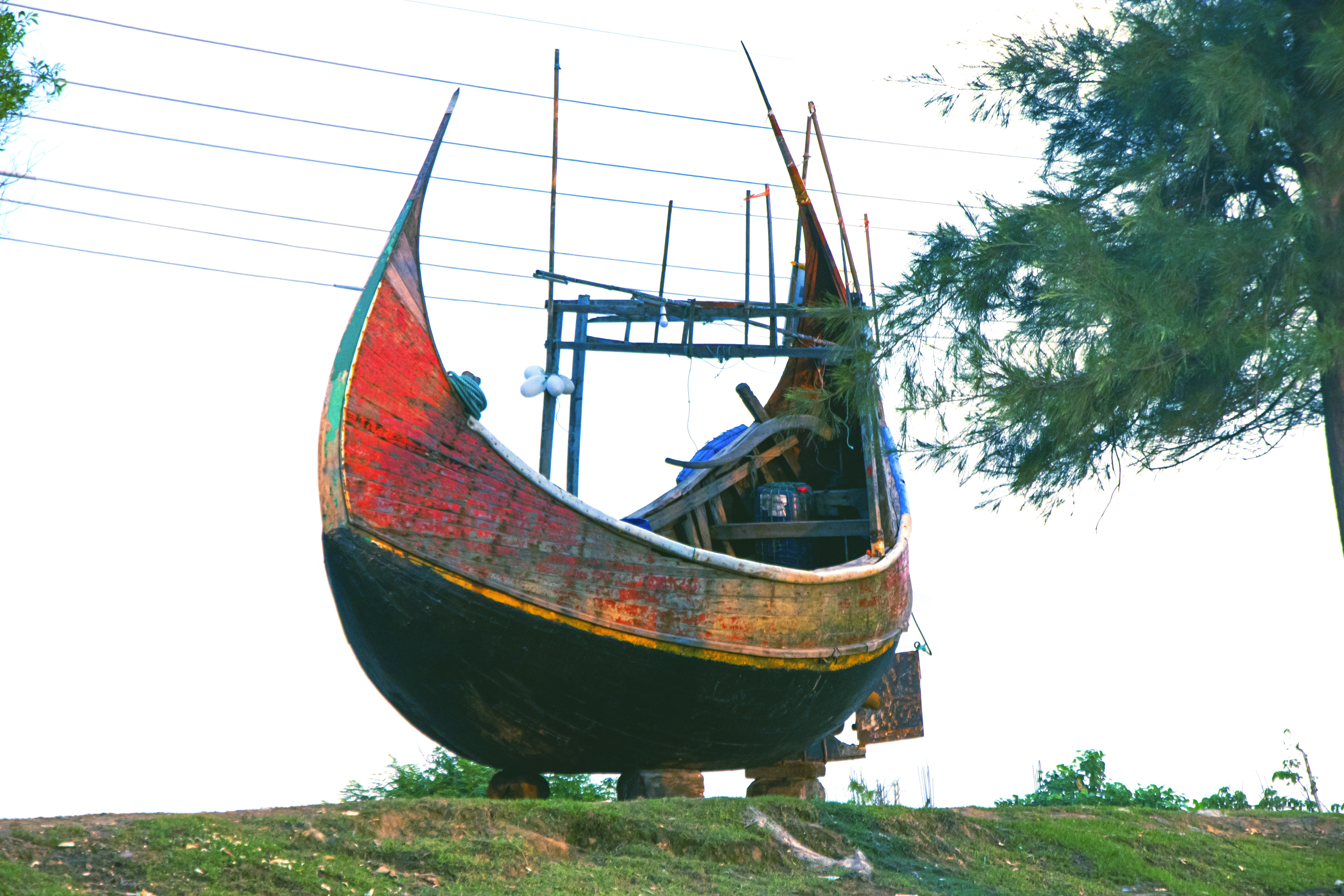 Red-hulled Vessel on Dry Ground Framed by a Web of Cables