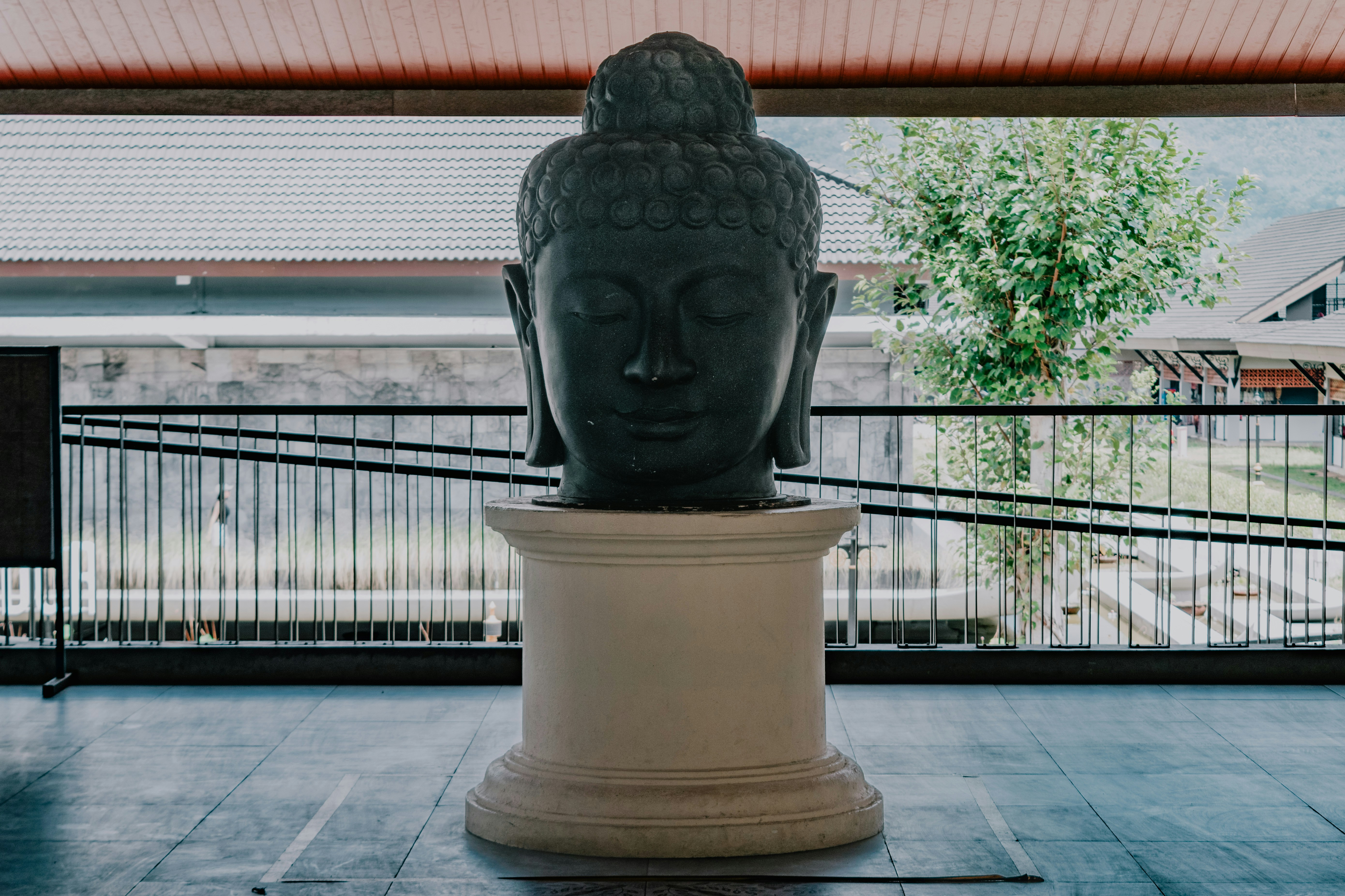 Meditative Guardian: A Central Buddha Statue Amid a Quiet Terrace