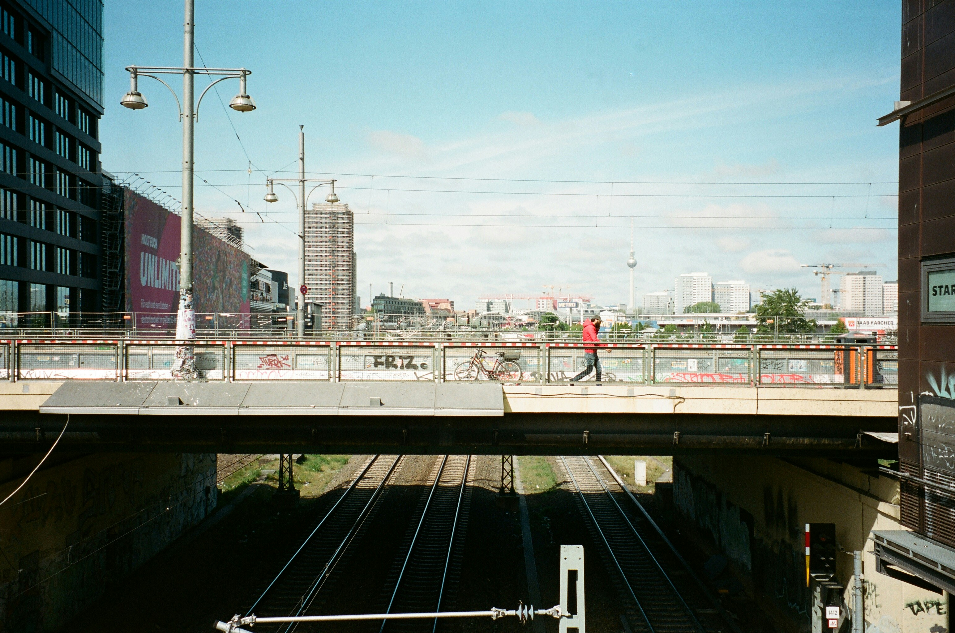 Person walks across bridge over railway tracks. photo – Free Film ...