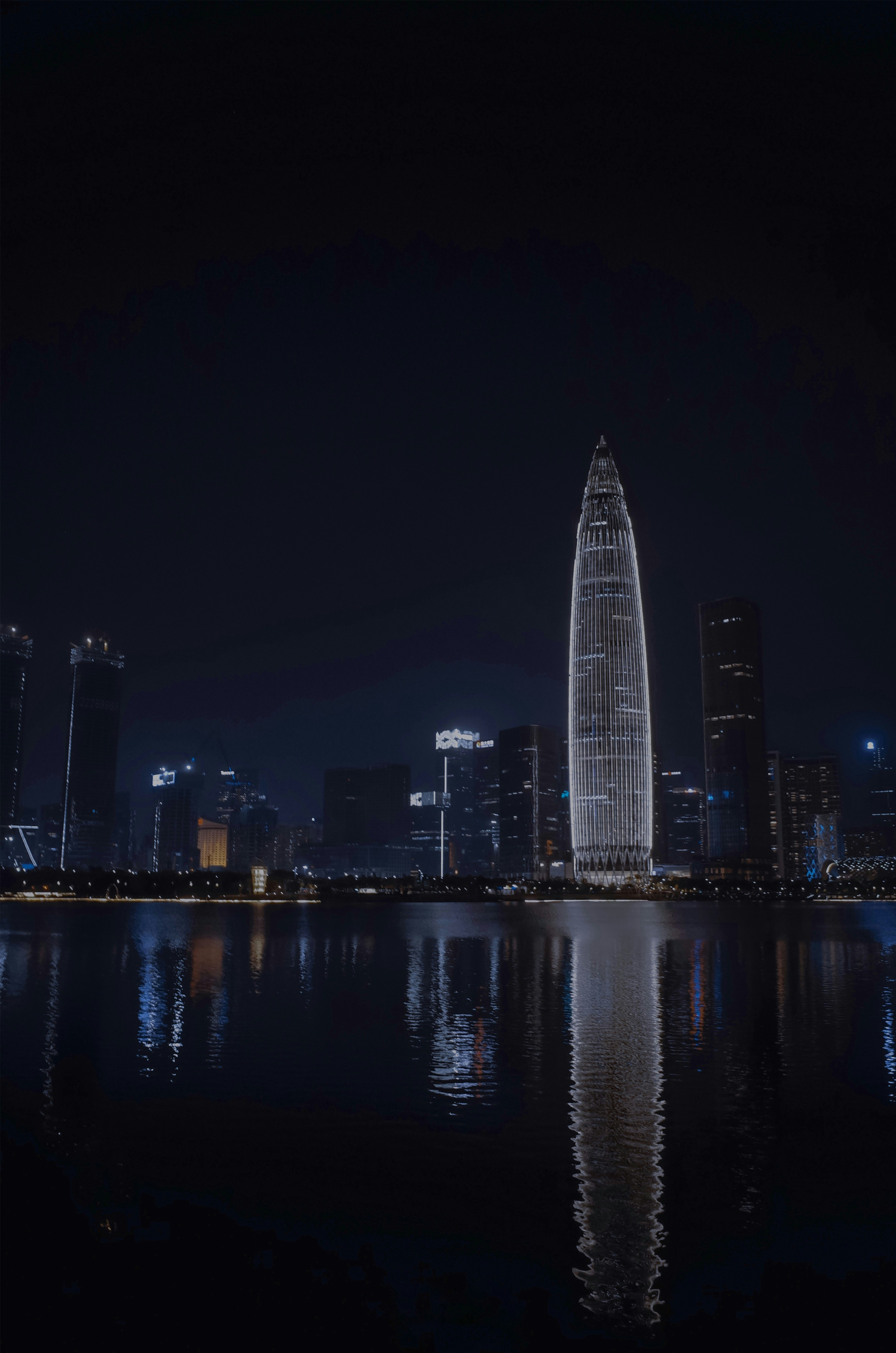 The Night Needle Rises Over a Glassy Harbor Skyline
