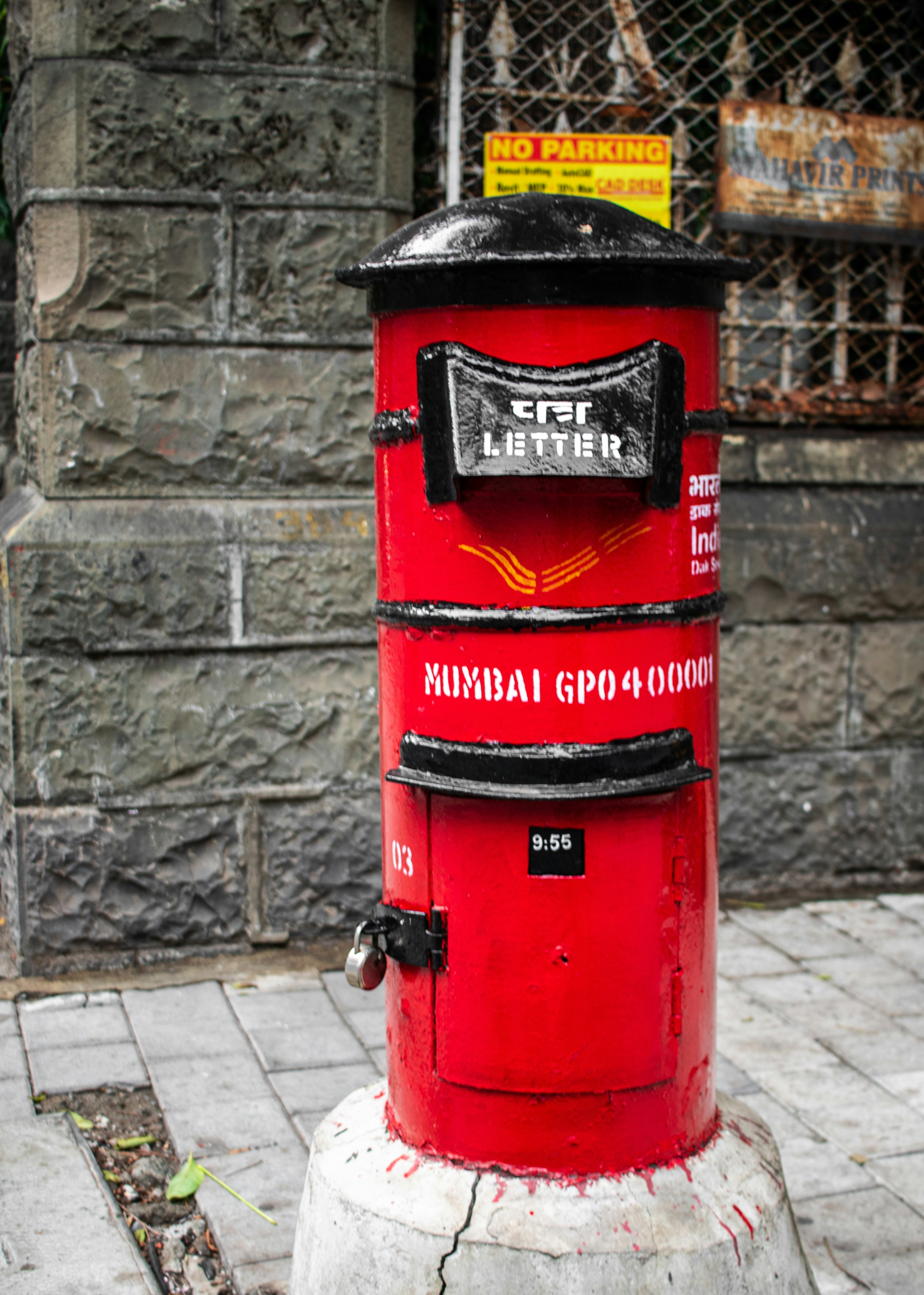 Crimson Mumbai GPO Postbox Framed by a Weathered Stone Wall