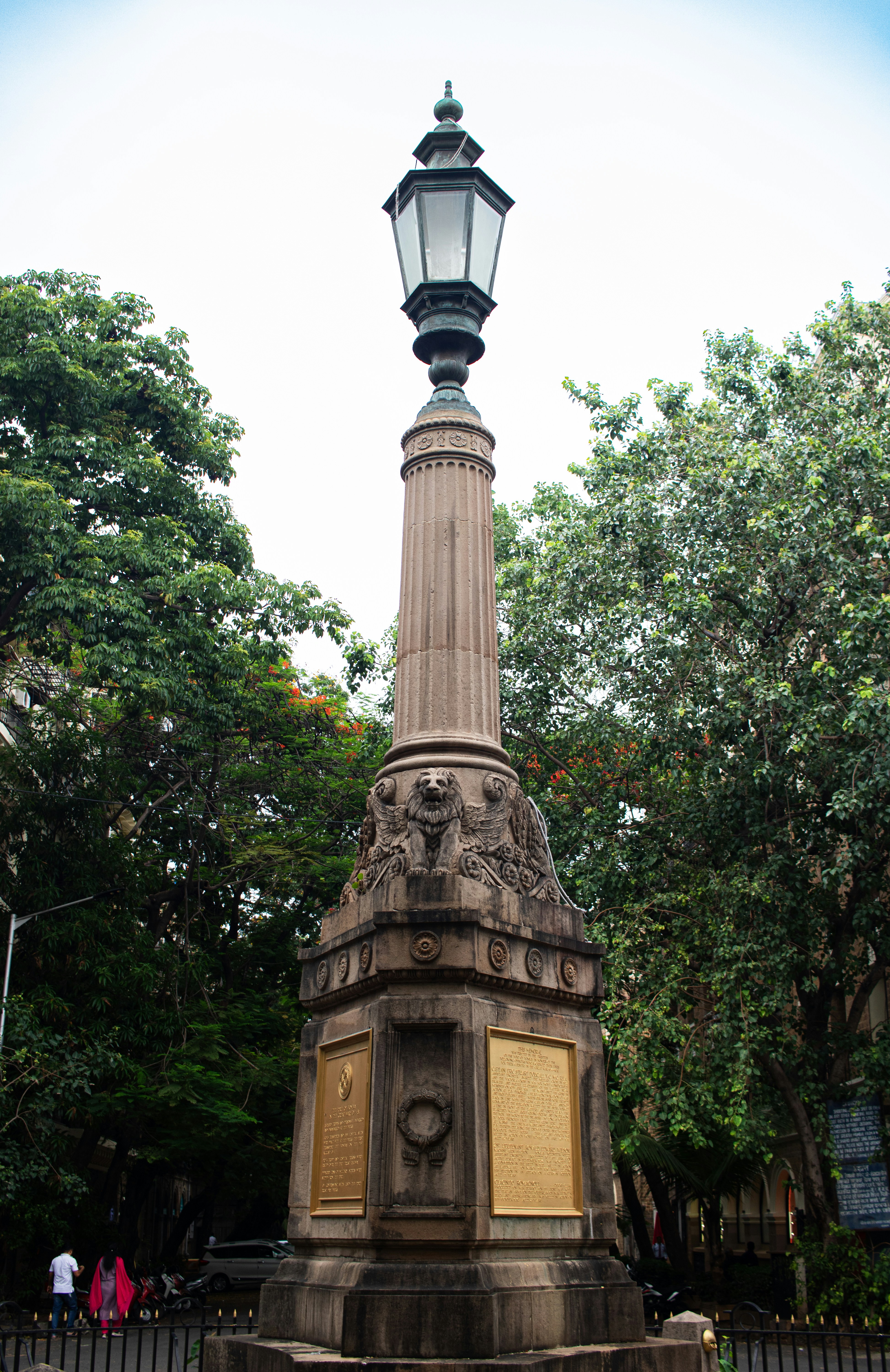 Obelisk Lantern Rising at a Tree-Lined City Park