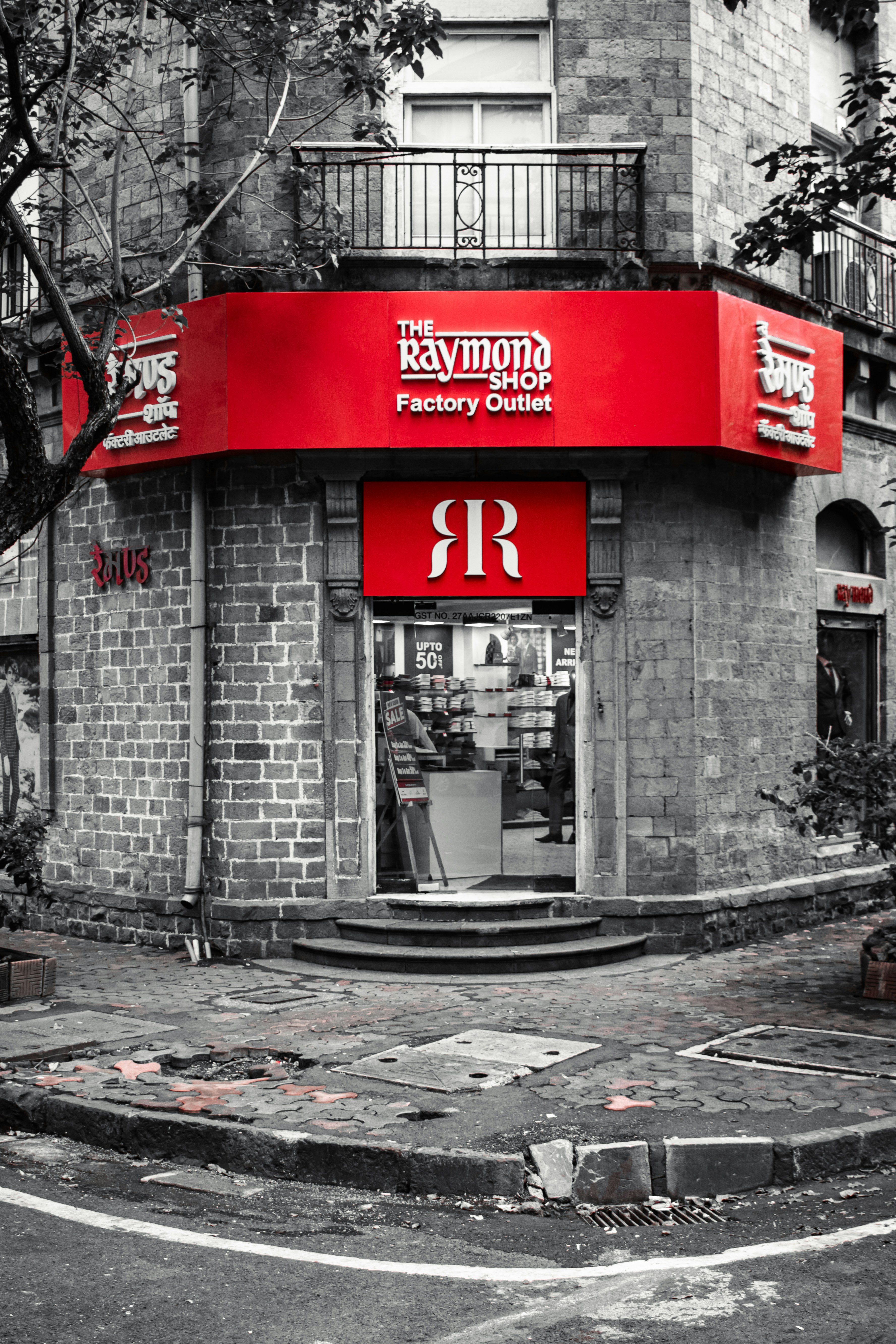 Red Sign, Brick Facade: The Raynond Shop Corner