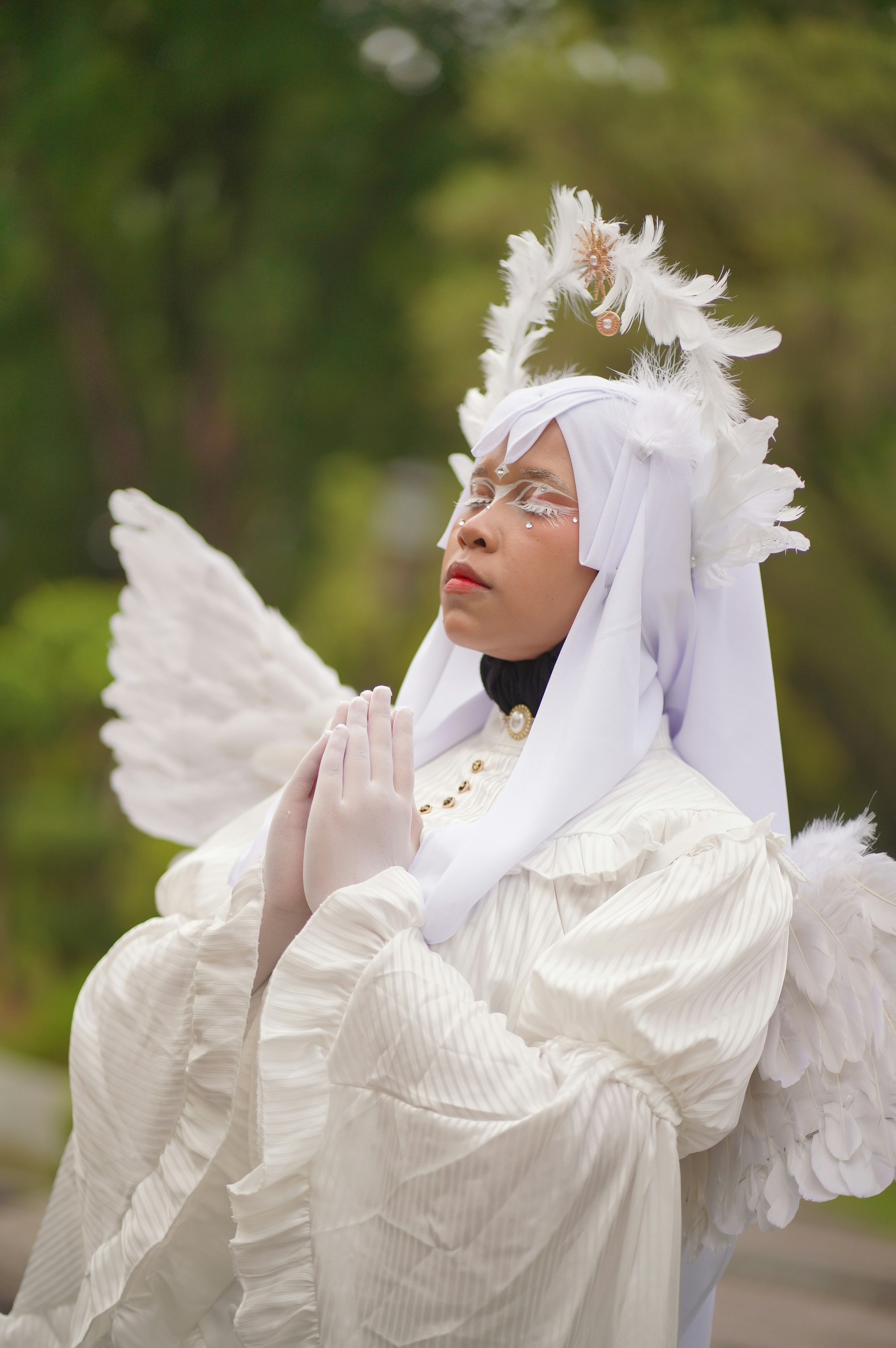 An angel-themed cosplayer poses peacefully. photo – Free Woman Image on ...