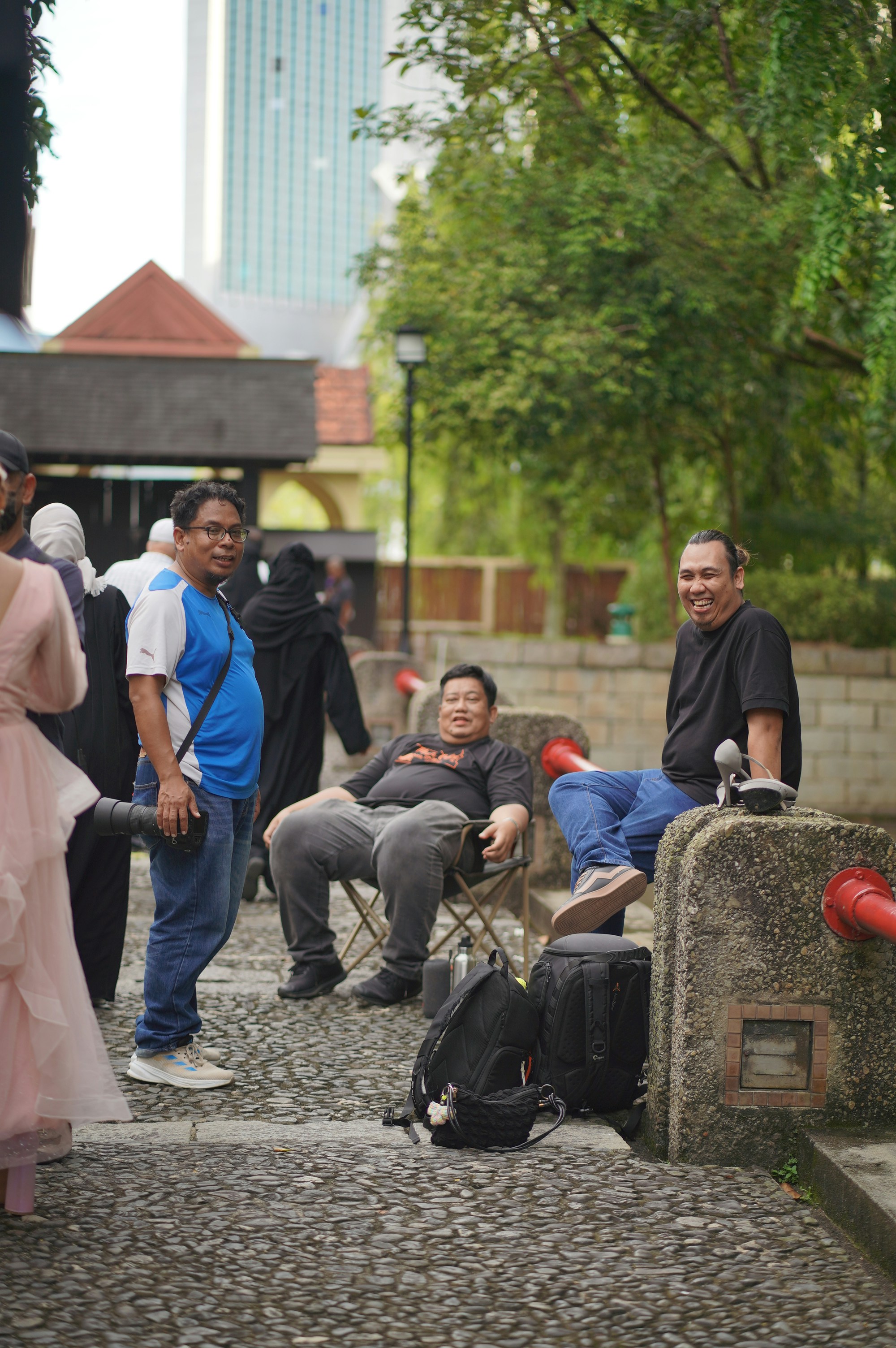 Group of individuals relaxing in an urban setting, with a blend of casual attire and surroundings. The scene captures a moment of camaraderie and leisure.