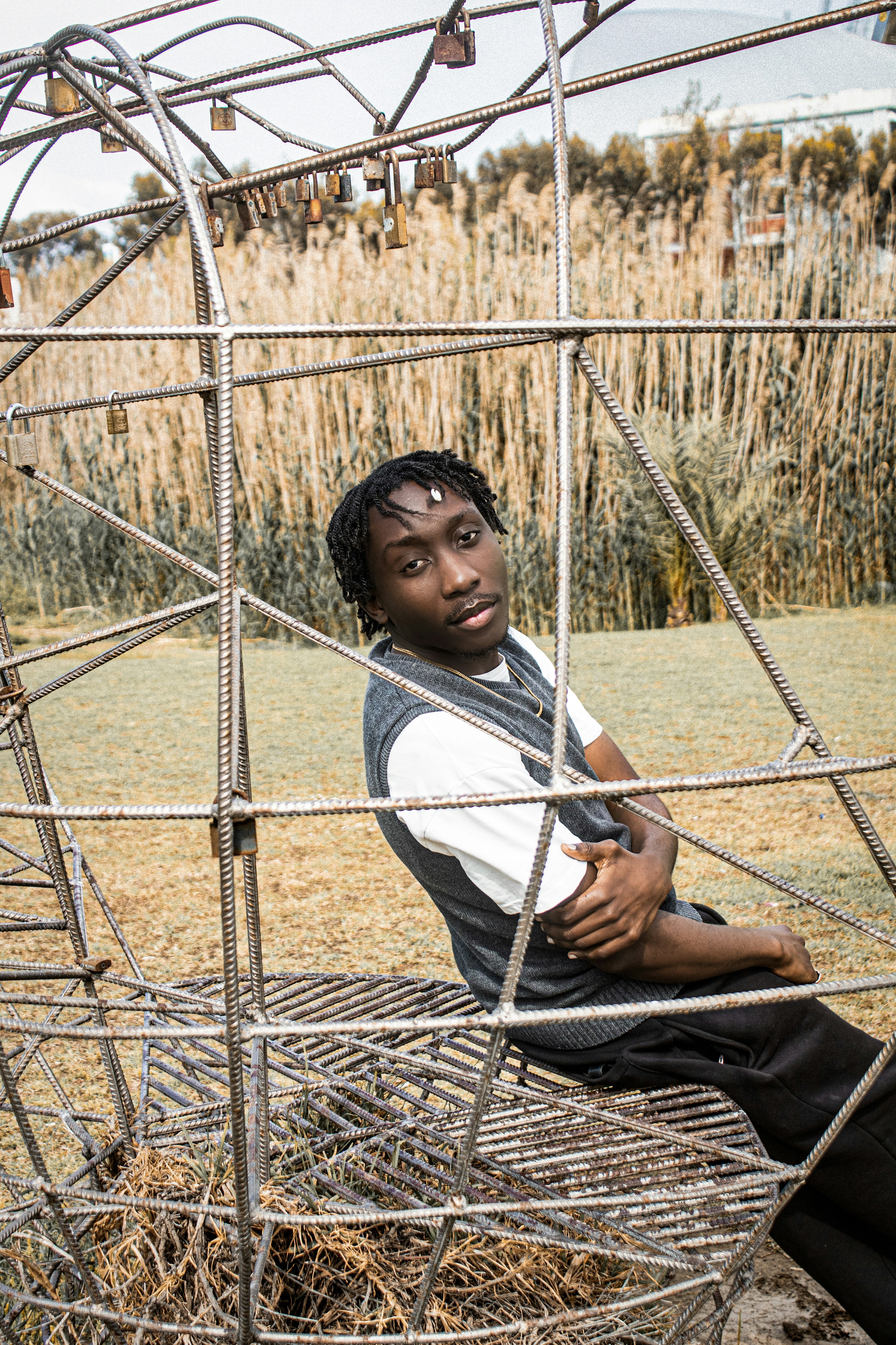 A man poses in an art installation outdoors. photo – Free Portrait ...