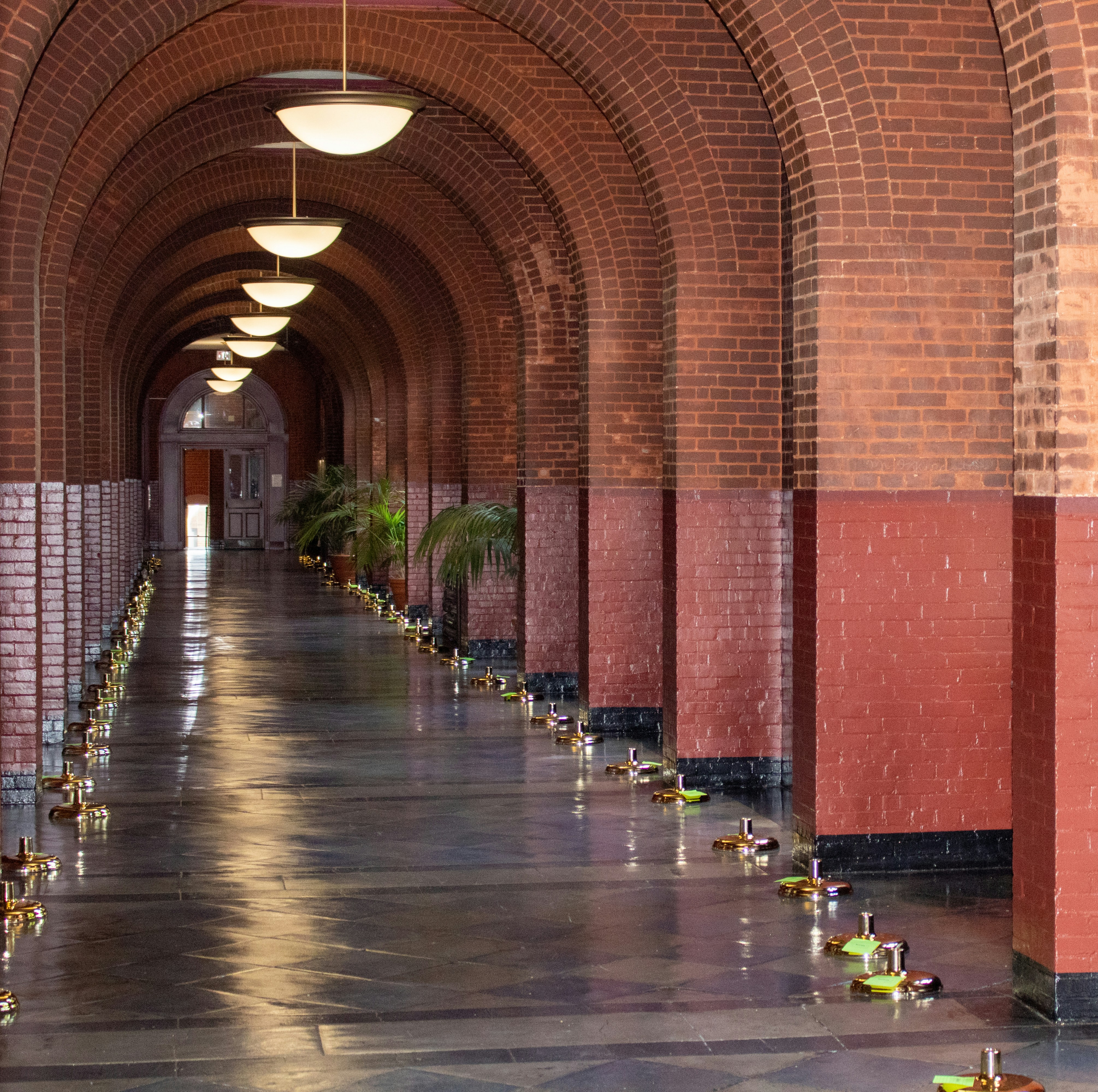A quiet moment in the red-brick corridor behind Georgetown’s iconic Healy Hall—one of America’s most storied academic settings. Founded in 1789, Georgetown is the oldest Catholic university in the U.S., with a campus shaped by centuries of Jesuit stewardship. This hall, echoing the style of Old North and the Sacred Heart Chapel, reflects the school's layered history. Nestled on the Potomac Palisades, Healy’s rear red brick facade blends with early campus structures, offering a somber yet harmonious contrast to its grand Gothic stone front.