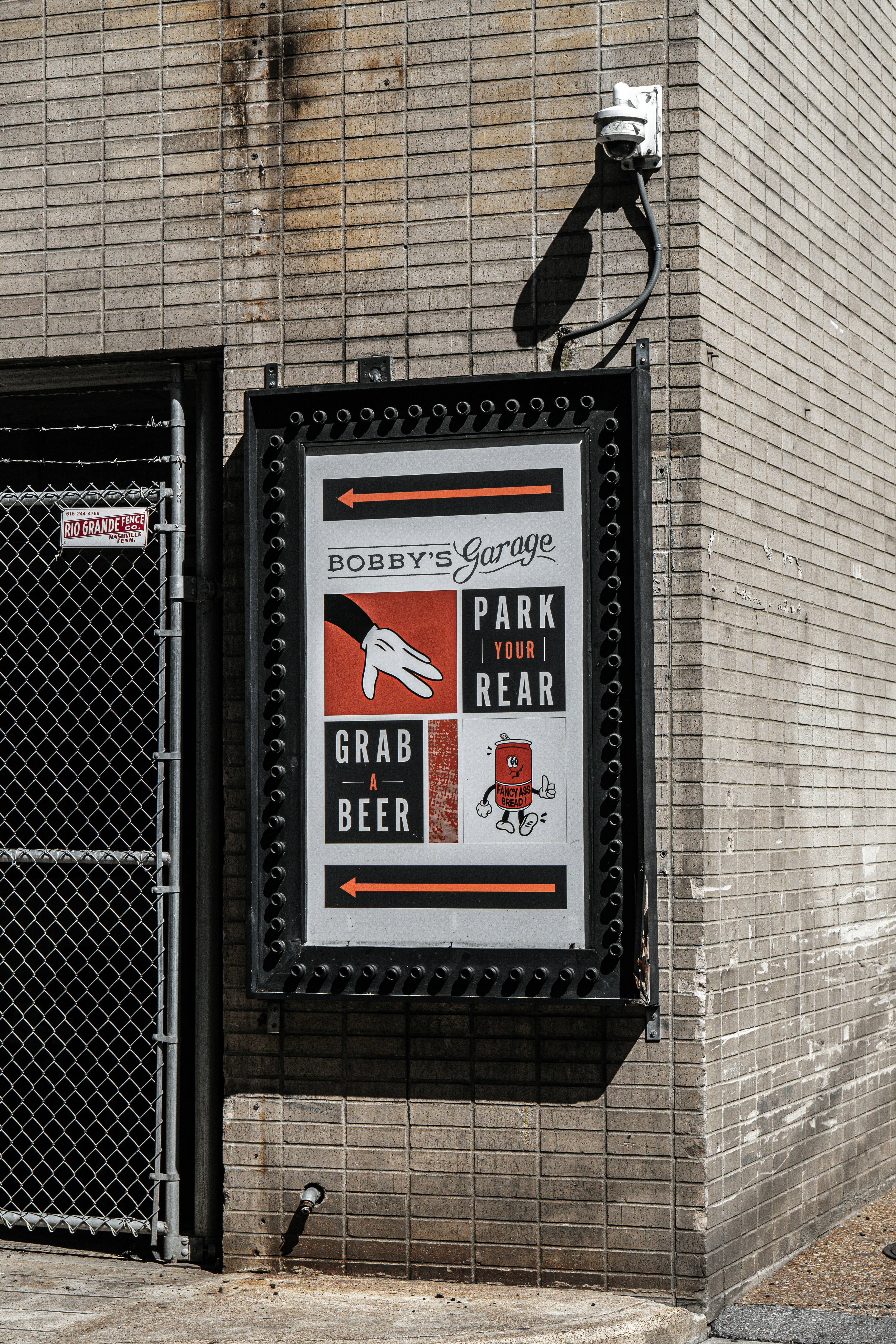Signboard of Bobby's Garage: Grab a Beer and Park Your Rear