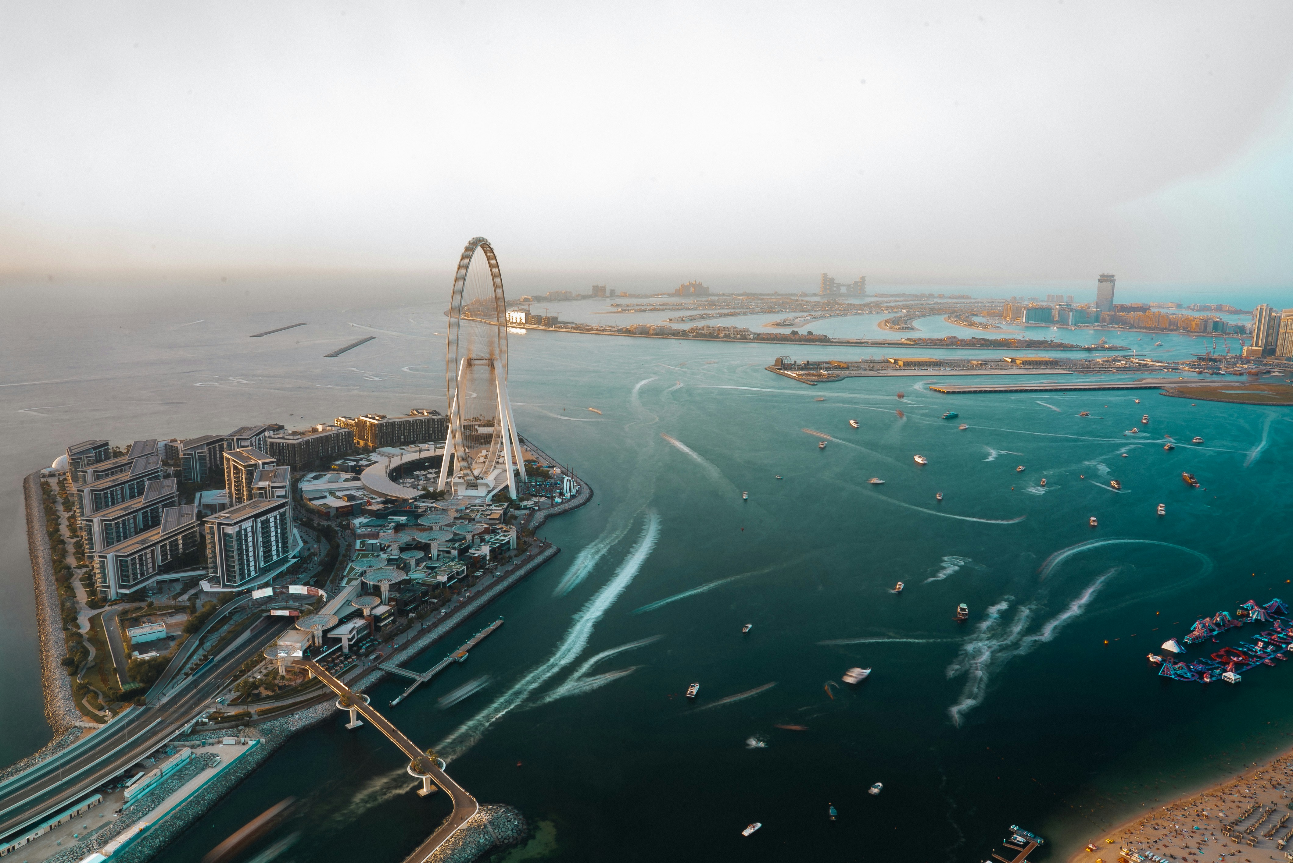 A ferris wheel towers over the water and the city. photo – Free Dubai ...