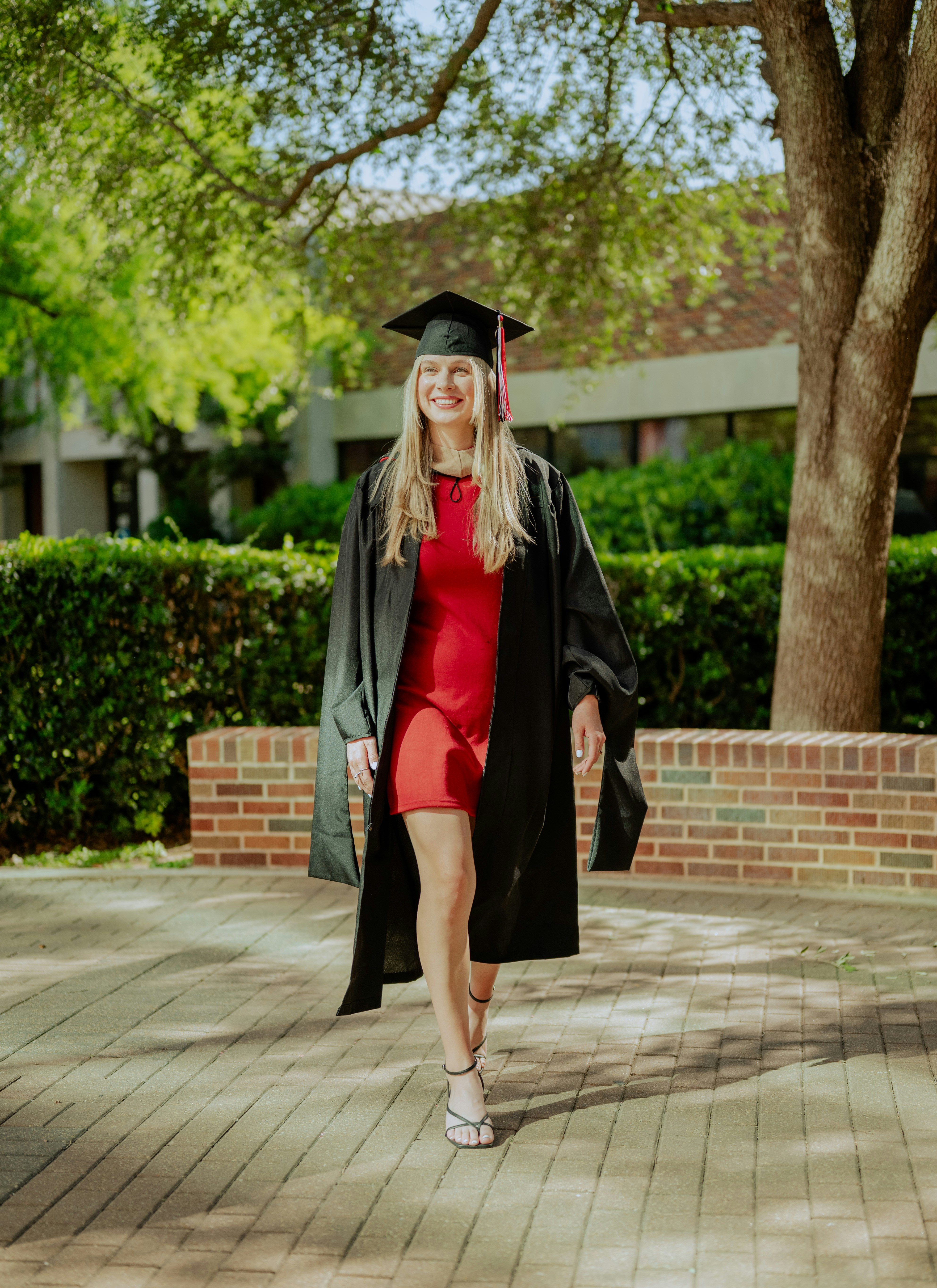 A smiling graduate walks toward the camera. photo – Free Graduation ...