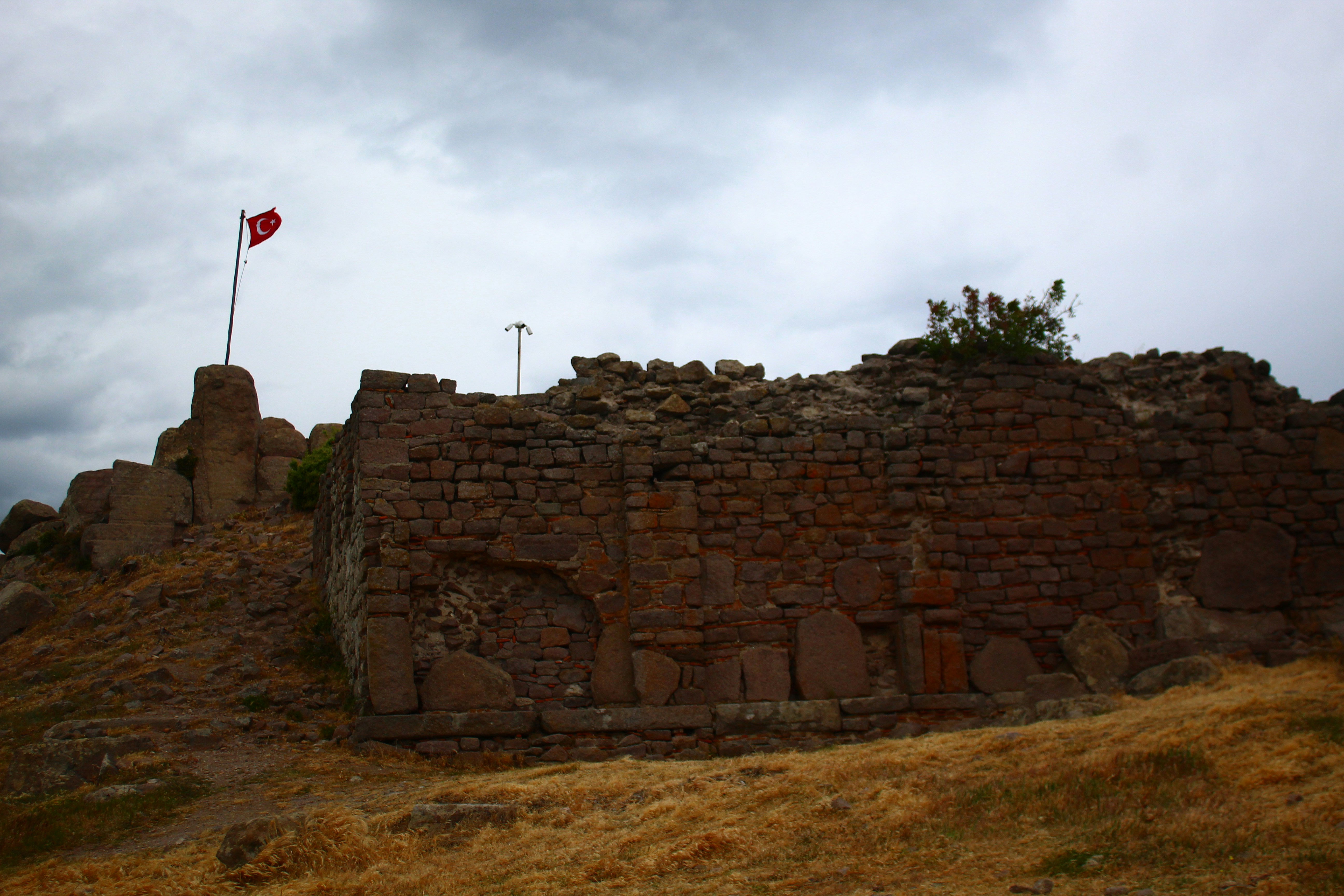 Flag over an ancient Turkish fortress under a brooding sky