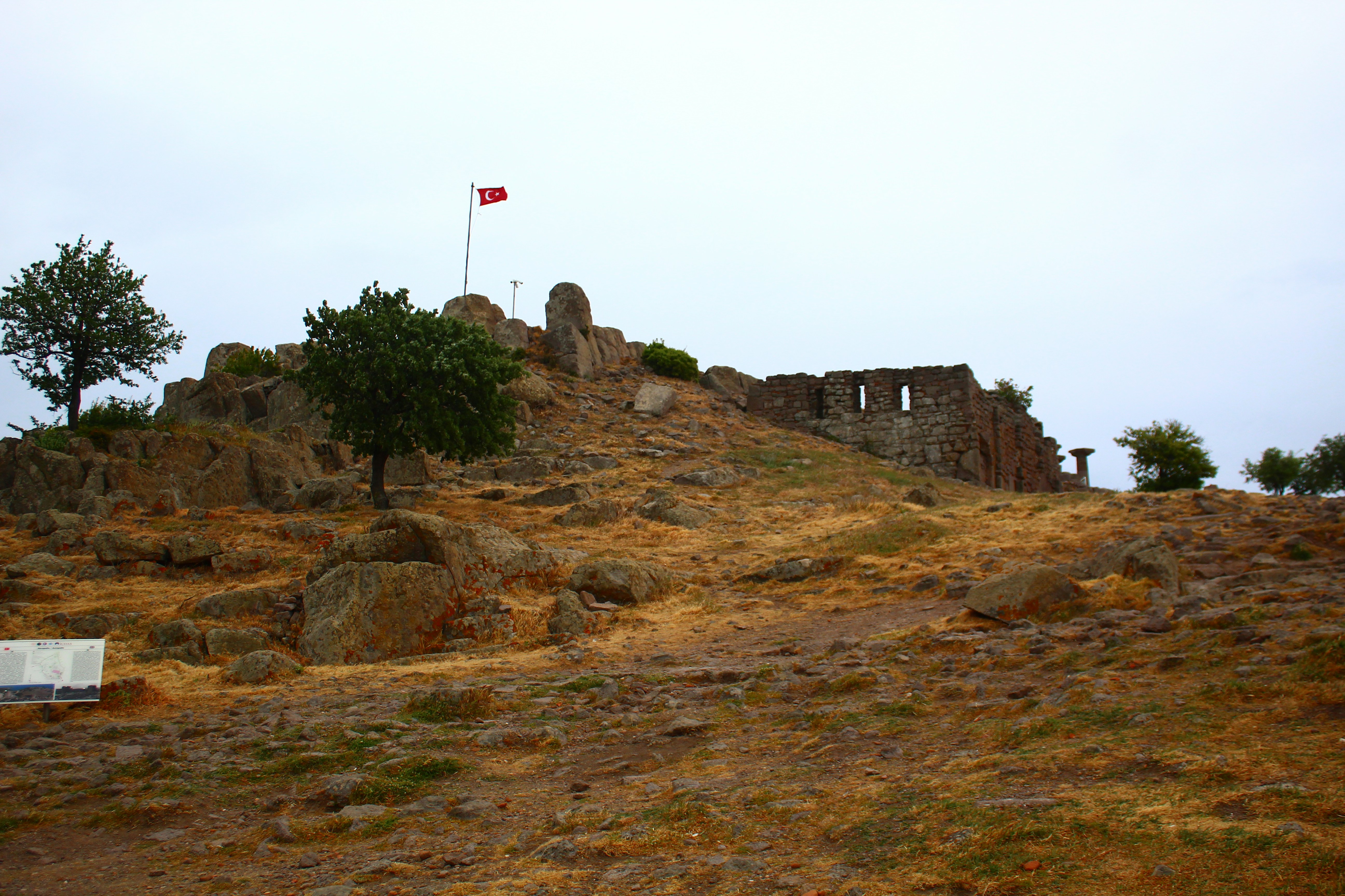 Flag at the Crown of a Weathered Hill Fort