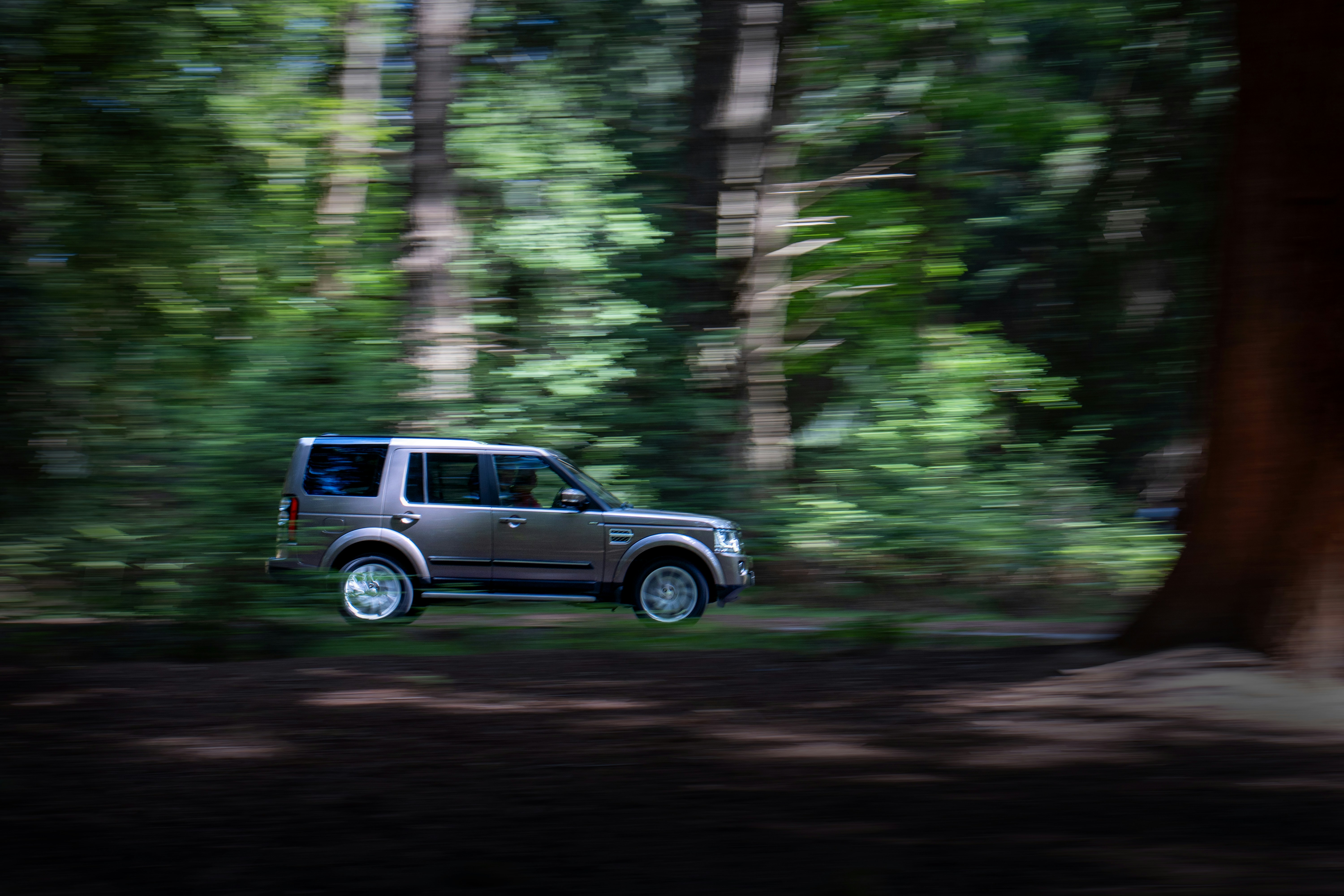 Pine Shadow Run: A Rugged SUV in a Blurred Forest Lane
