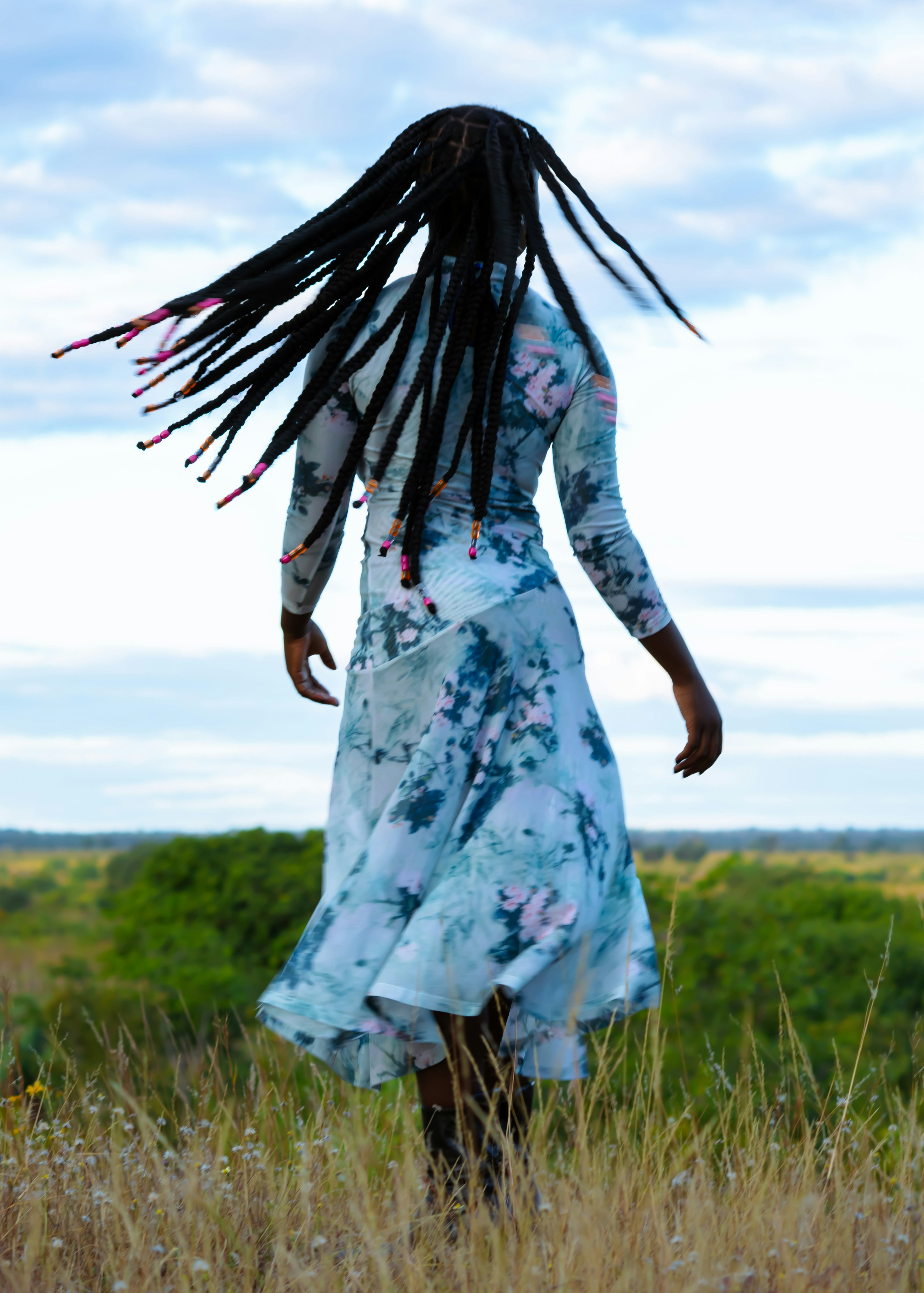 La femme danse joyeusement dans un champ, les cheveux coulant librement ...
