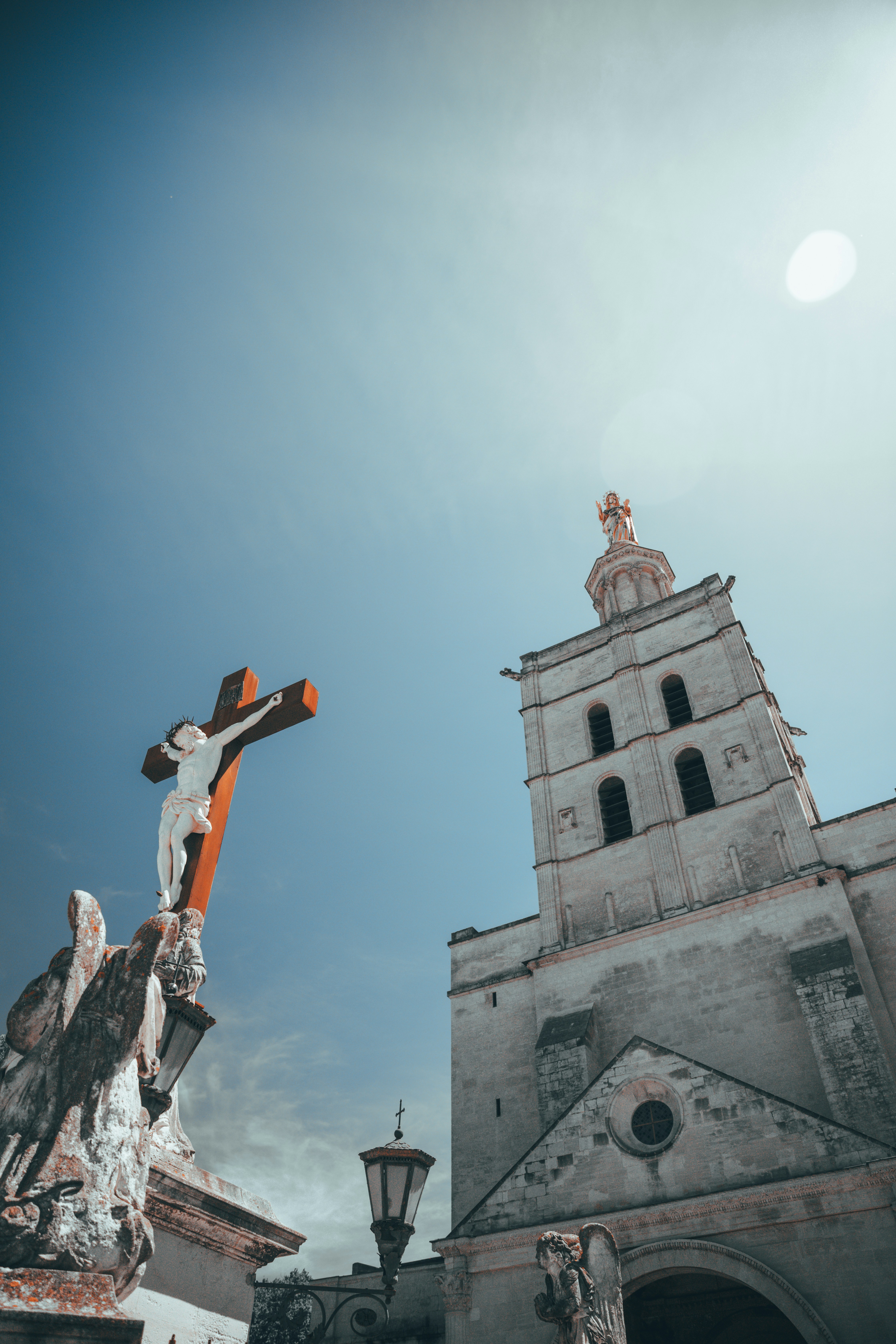 Foreground Crucifix and Towering Church Against a Clear Blue Sky