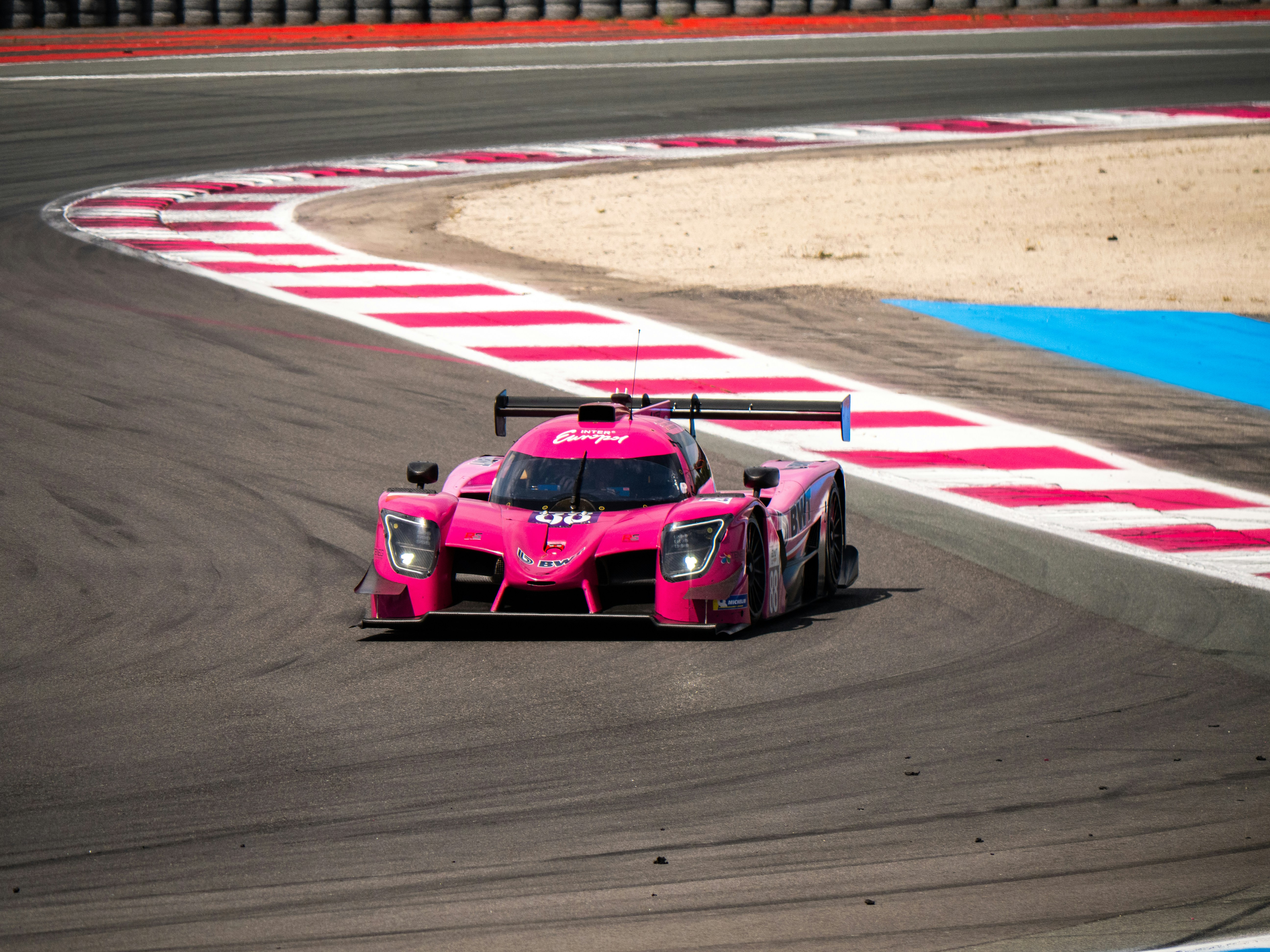 A pink race car speeds around a track. photo – Free Car Image on Unsplash