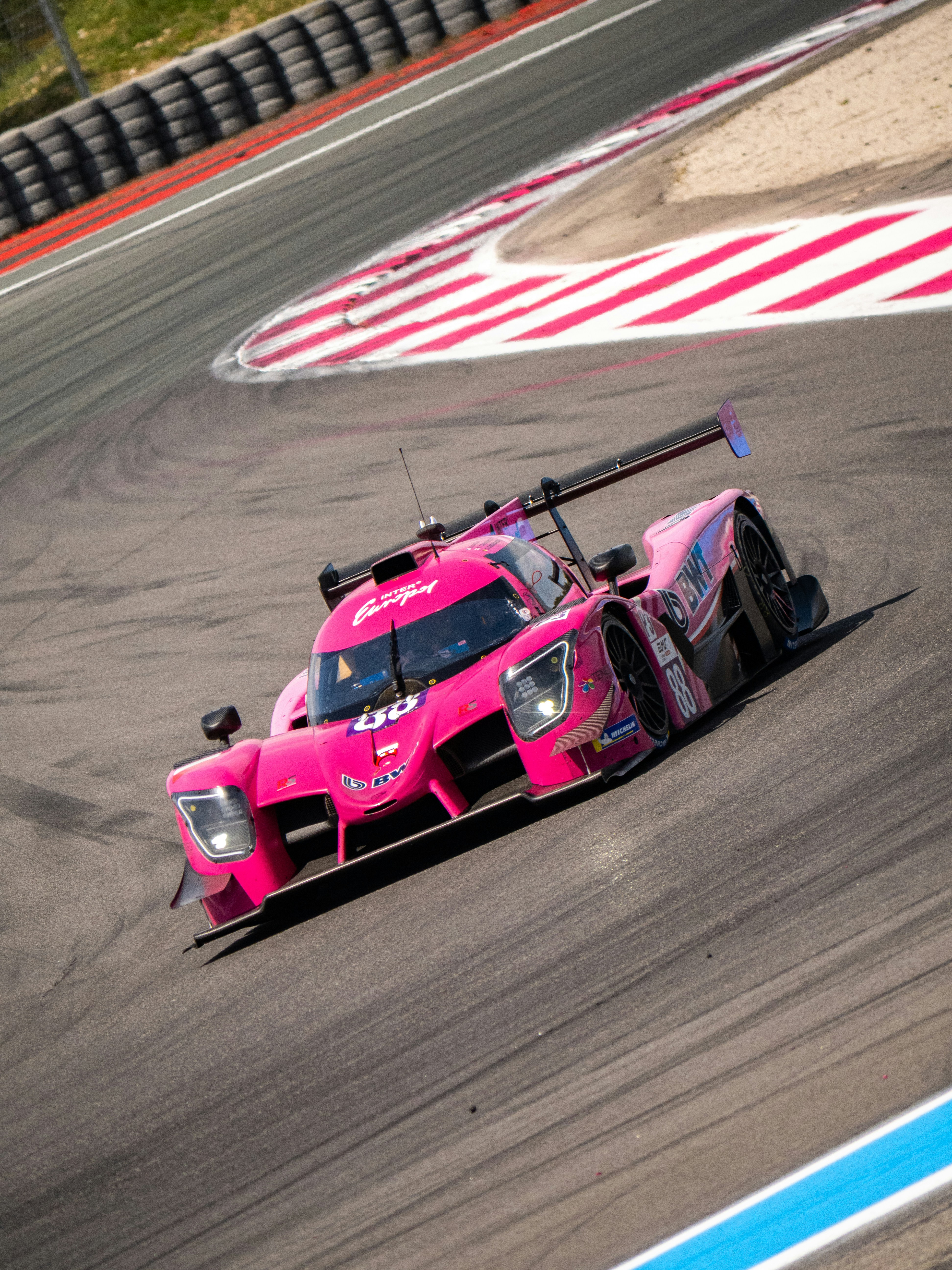 Pink racer taking the apex: a high-speed blaze on the curving track