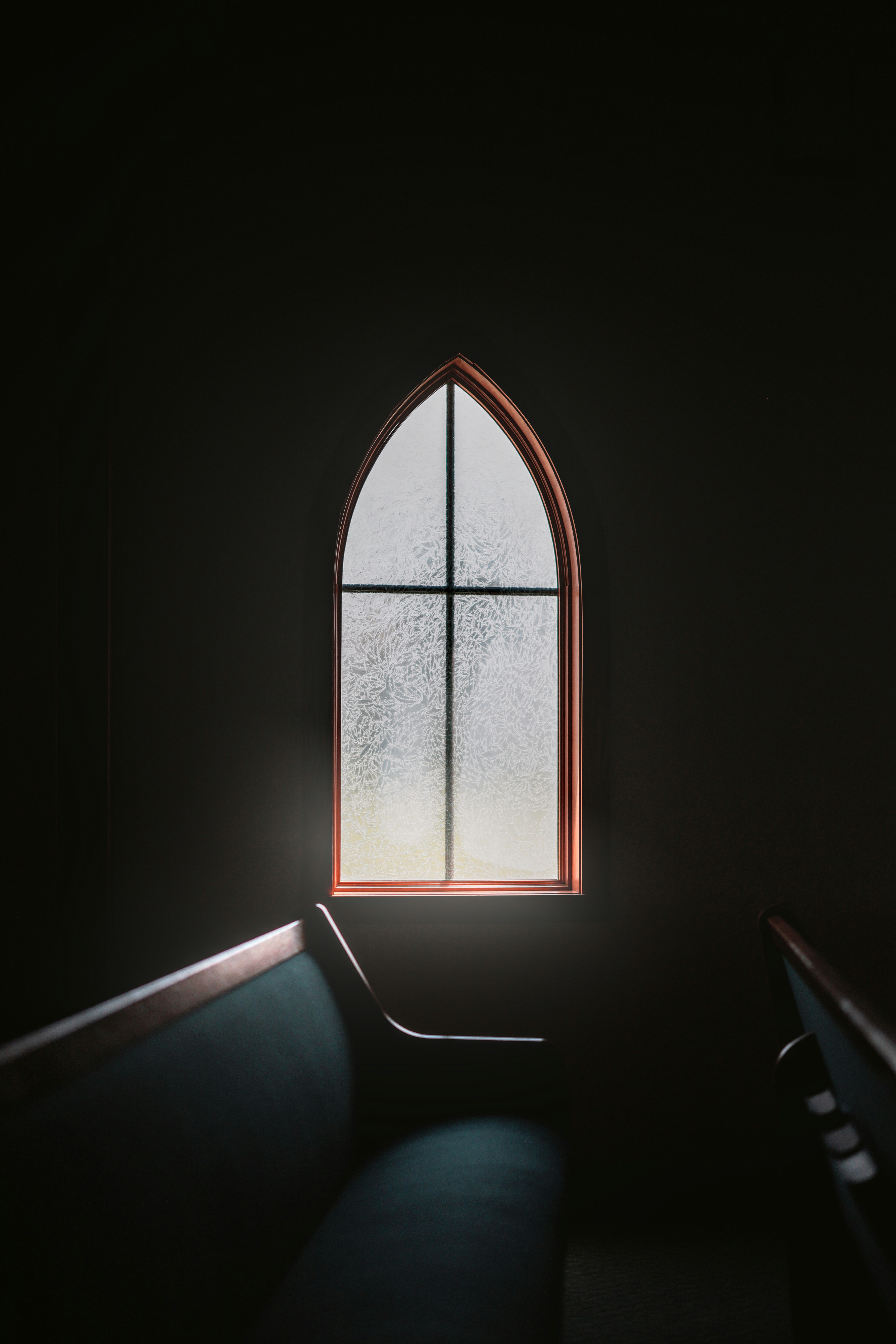 A church pew with light shining on it through a windowDaniel Gomez