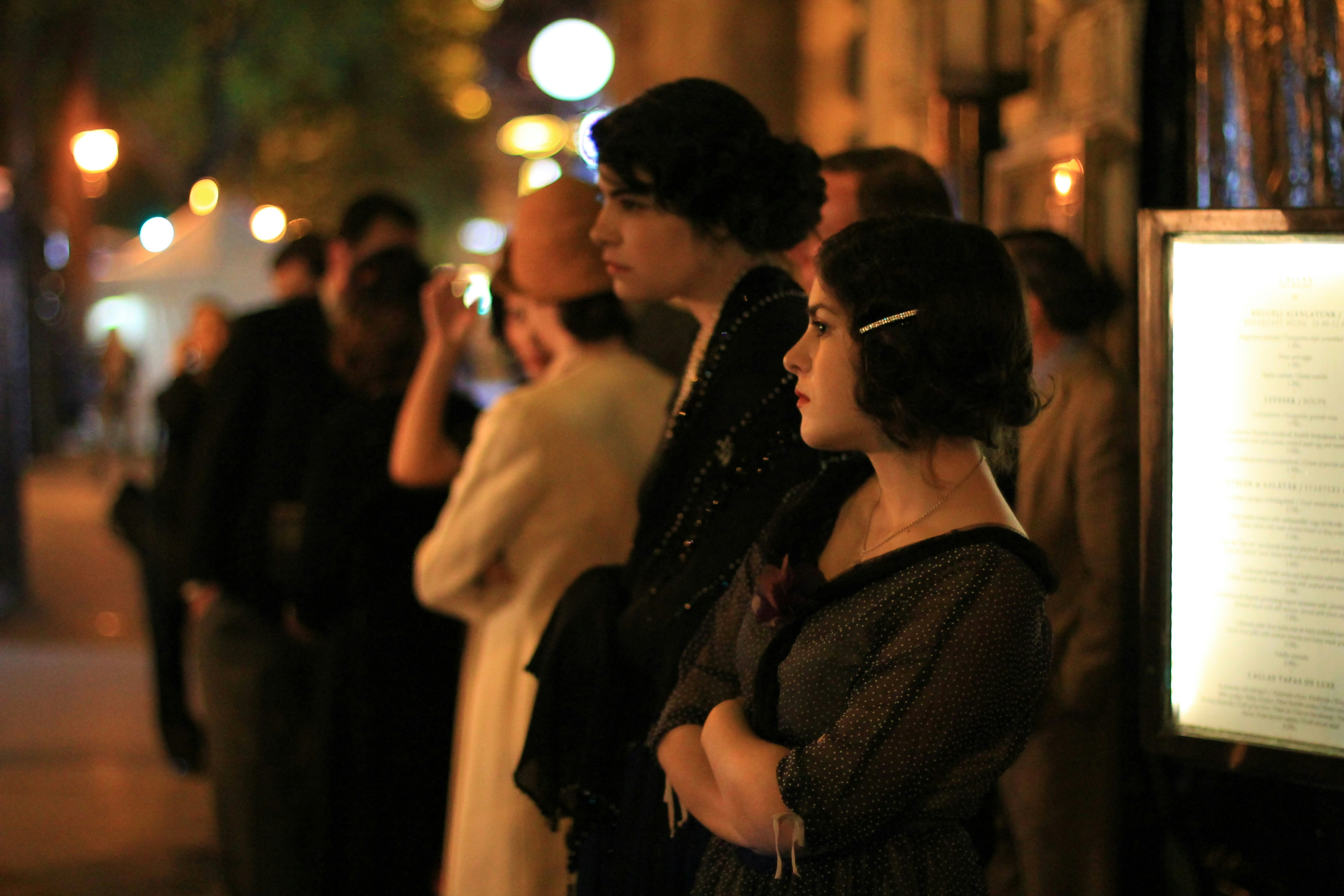 People in vintage clothing stand outside at night. photo – Free Street ...