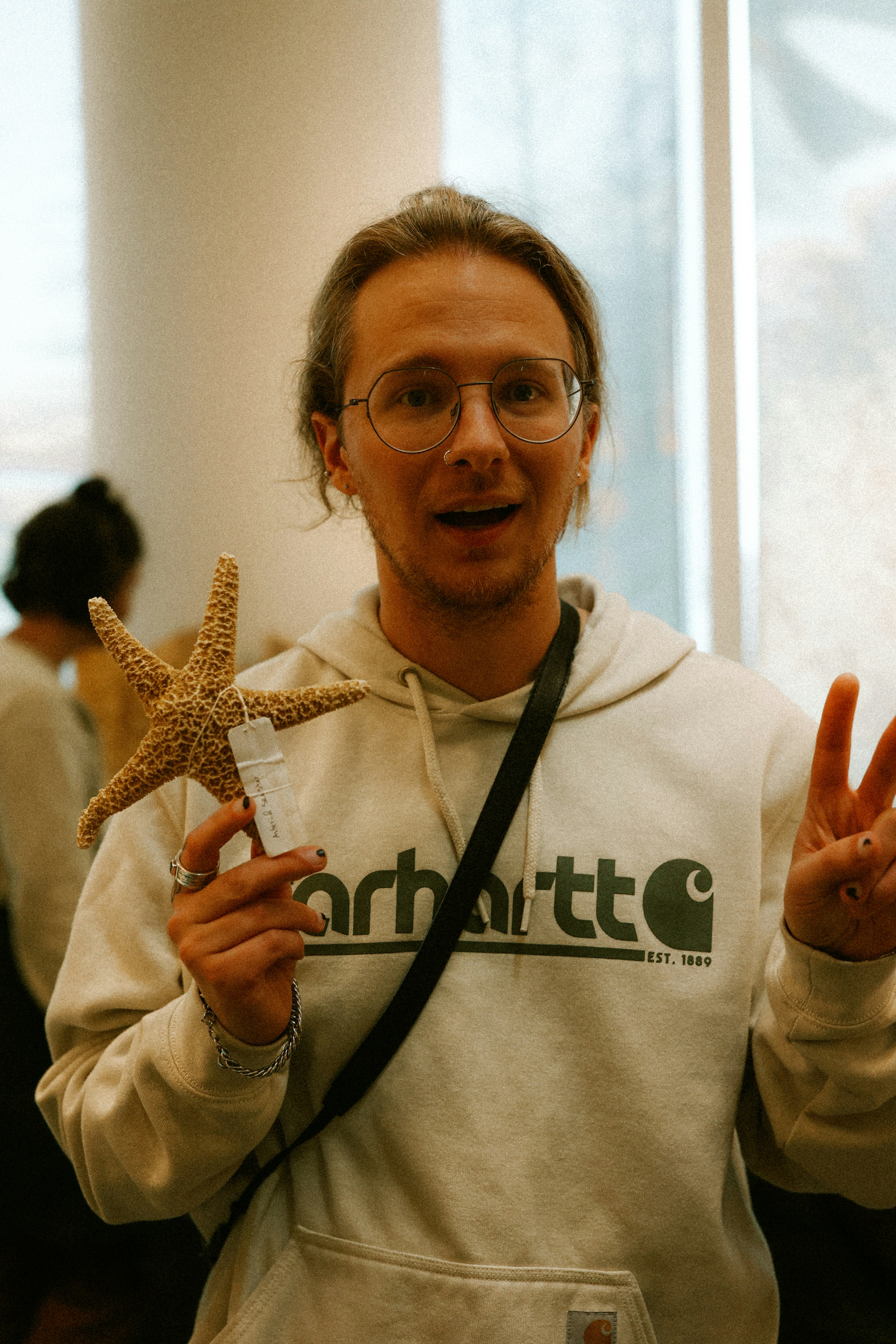 Man joyfully holds a starfish and gives a peace sign. photo – Free ...