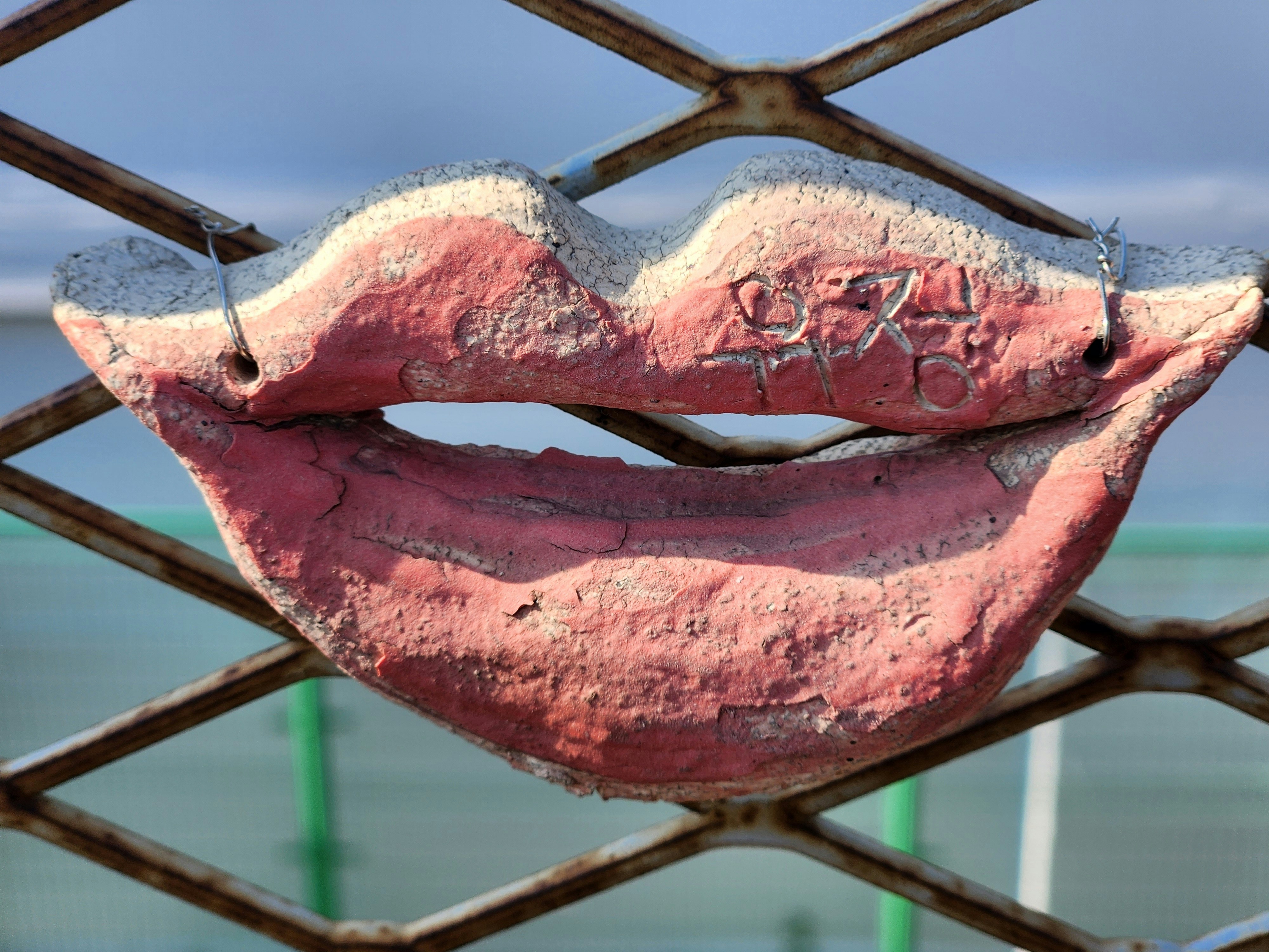 Painted lips hang on a metal grate. photo – Free Food Image on Unsplash