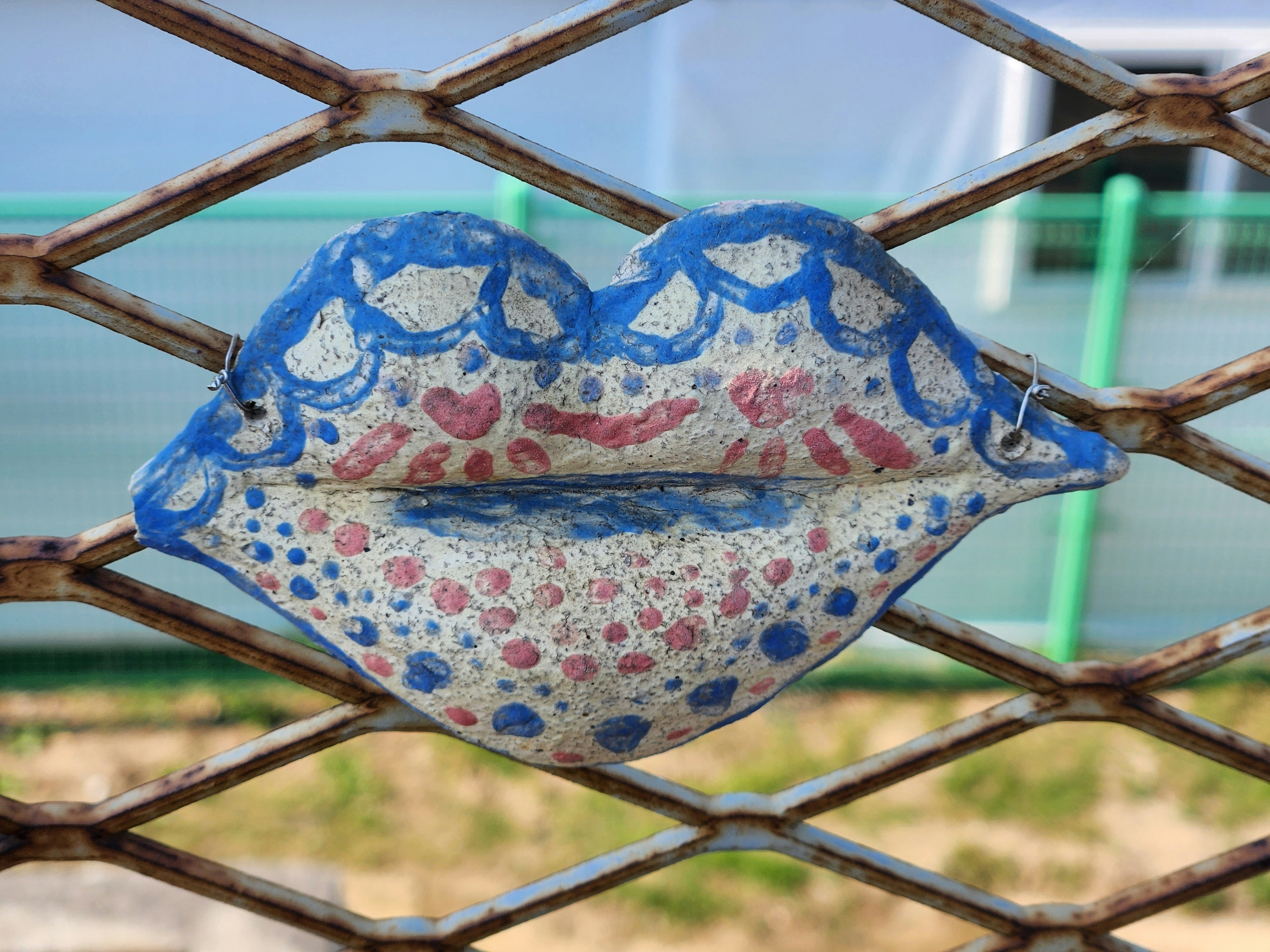Blue-Lace Ceramic Plate Framed by Chain-Link Fence