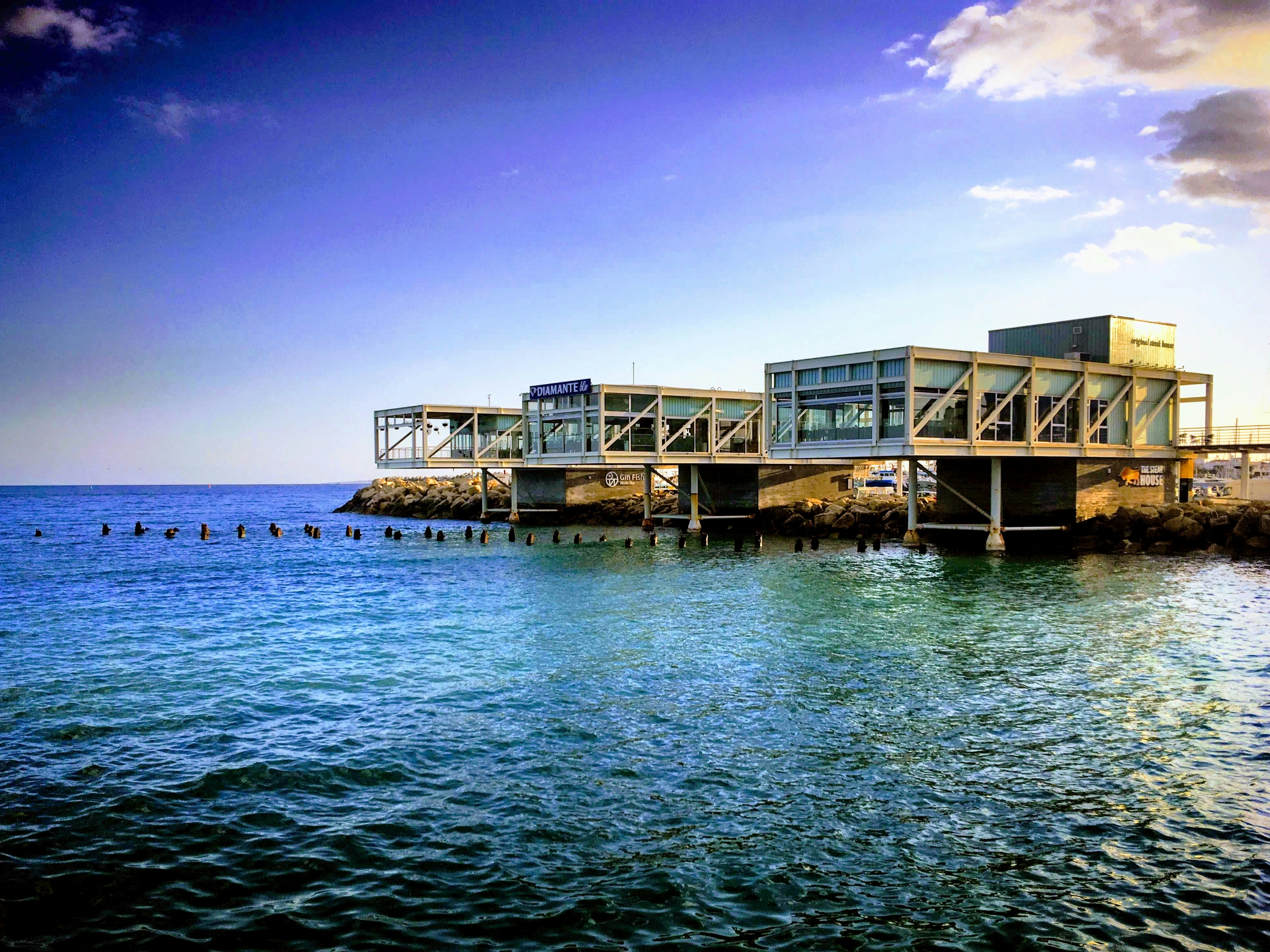 Glass-Fronted Pier Extends Over Turquoise Calm