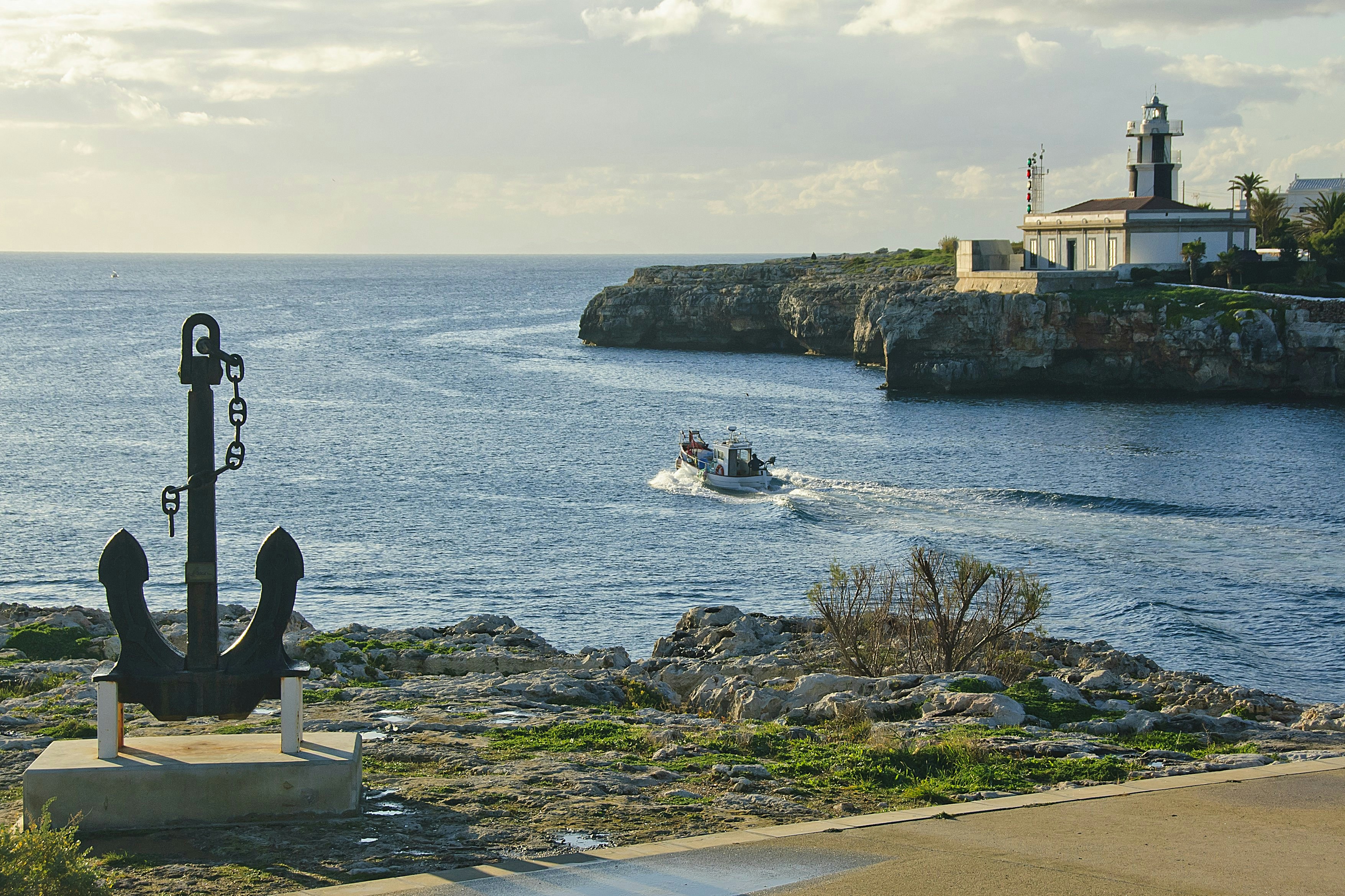 Anchor at the Shoreline: A Quiet Coastal Vignette with Boat and Lighthouse