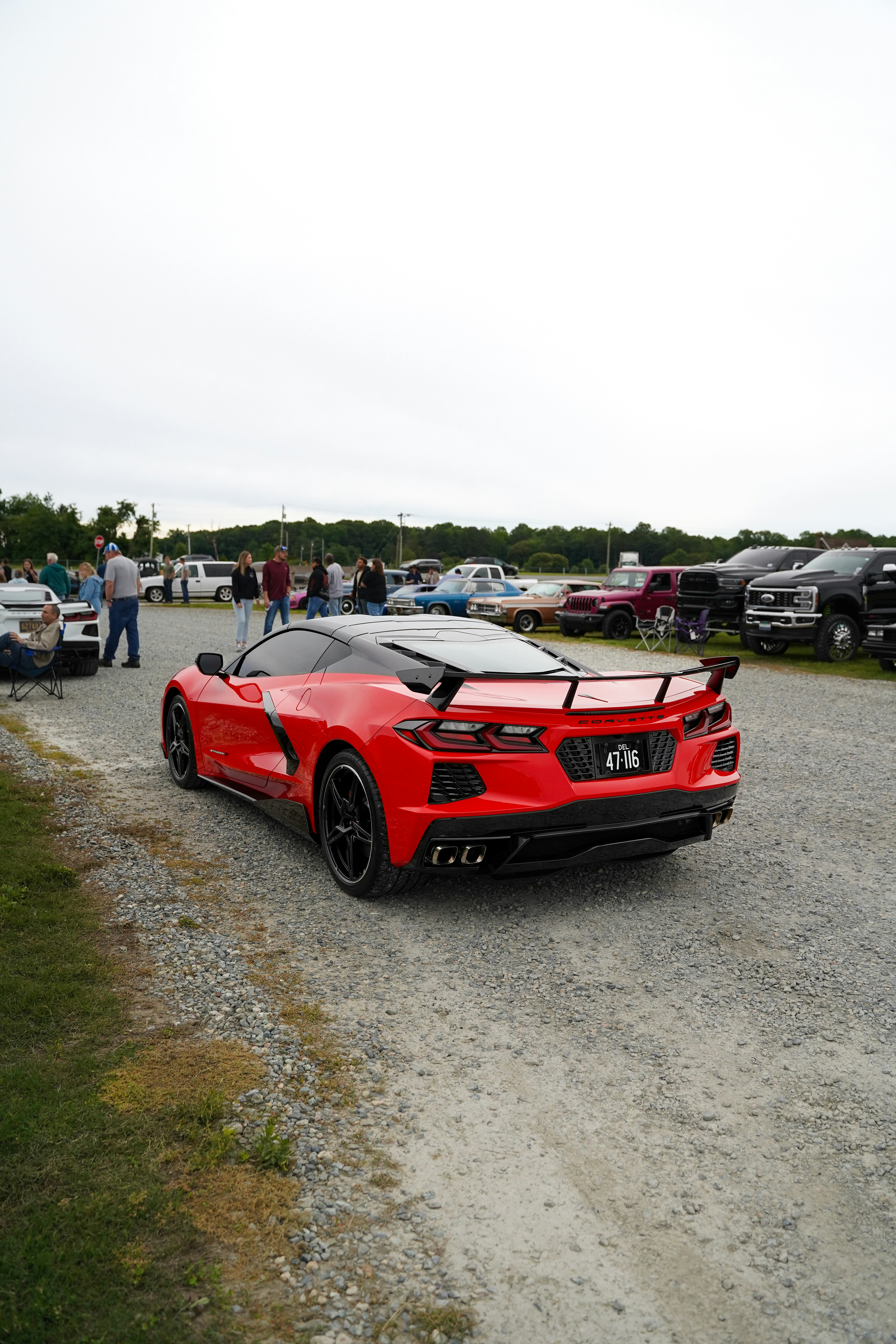 A red corvette sits at a car show. photo – Free Car Image on Unsplash