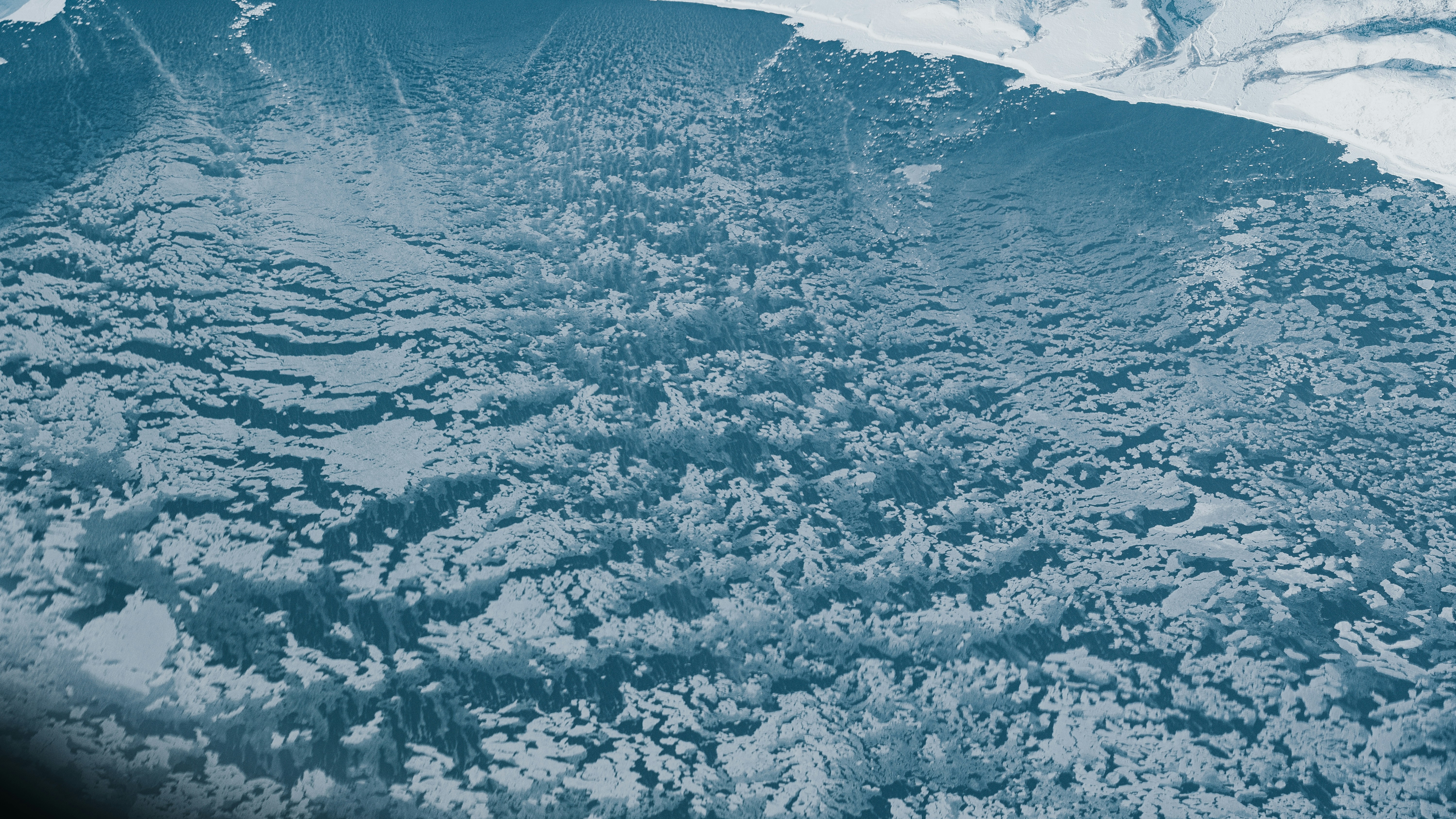 Intricate patterns of ice and snow cover a vast, frozen expanse, showcasing the beauty of winter's touch on the landscape.