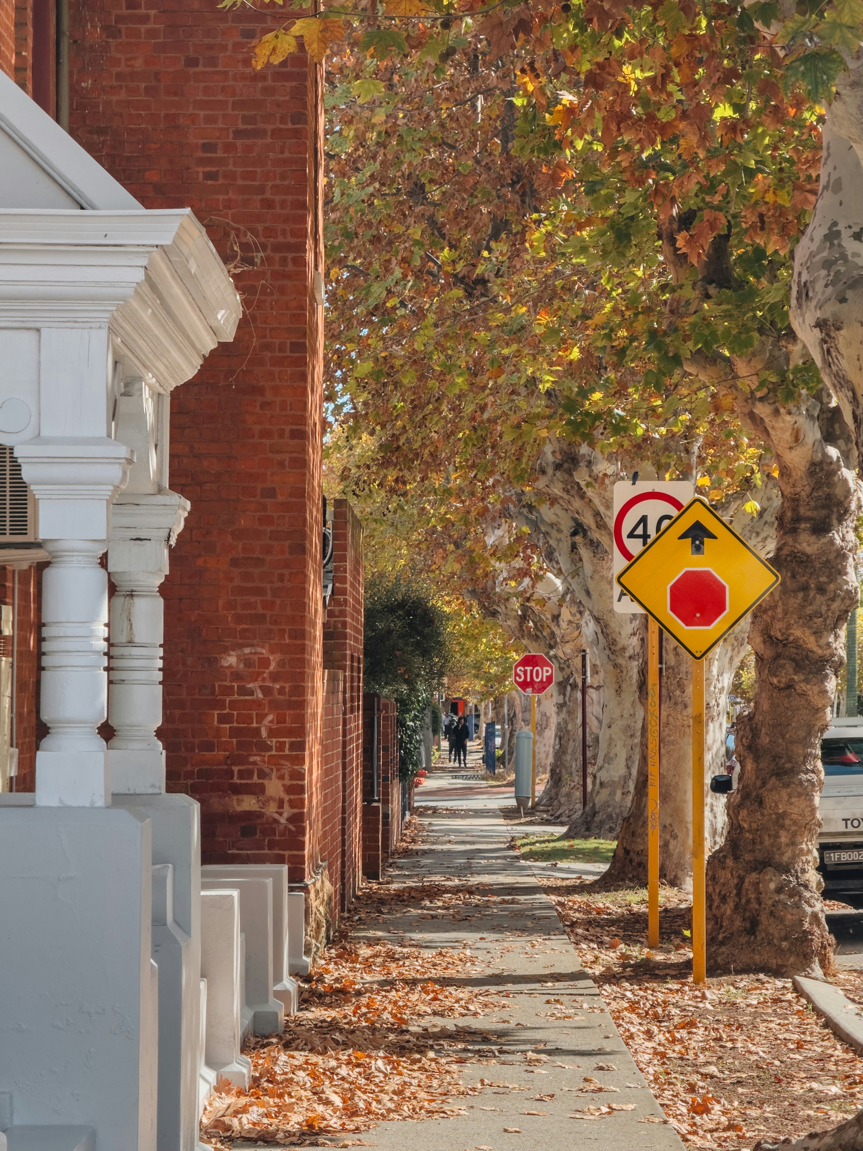Autumn Quiet along Brick-Colonnade: A Distant Pedestrian in Dappled Light