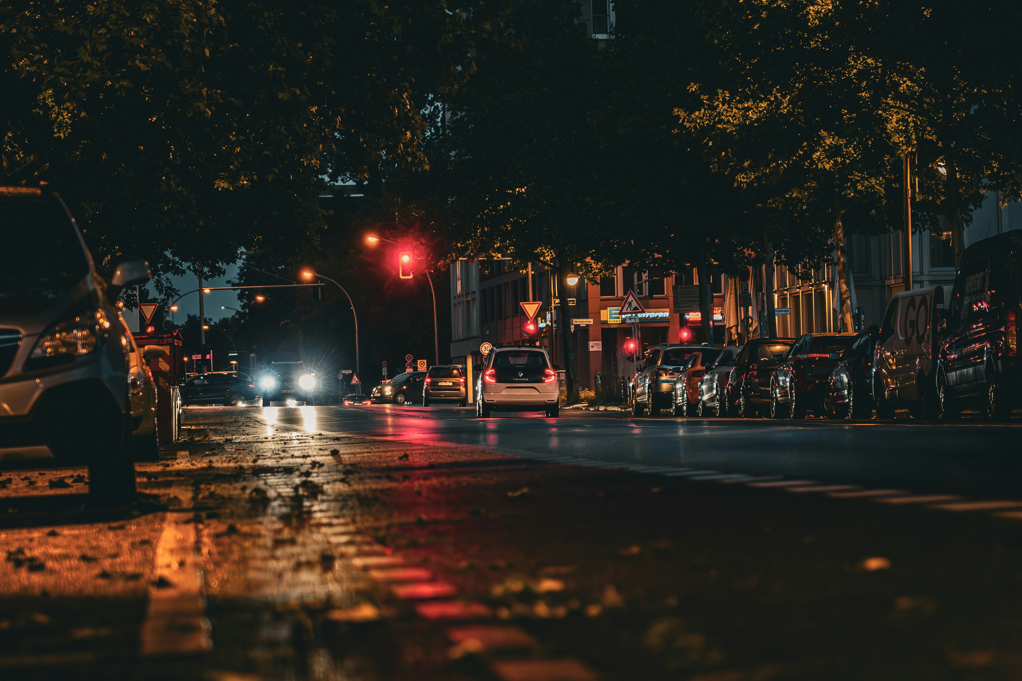 Nighttime street scene with cars and city lights.
