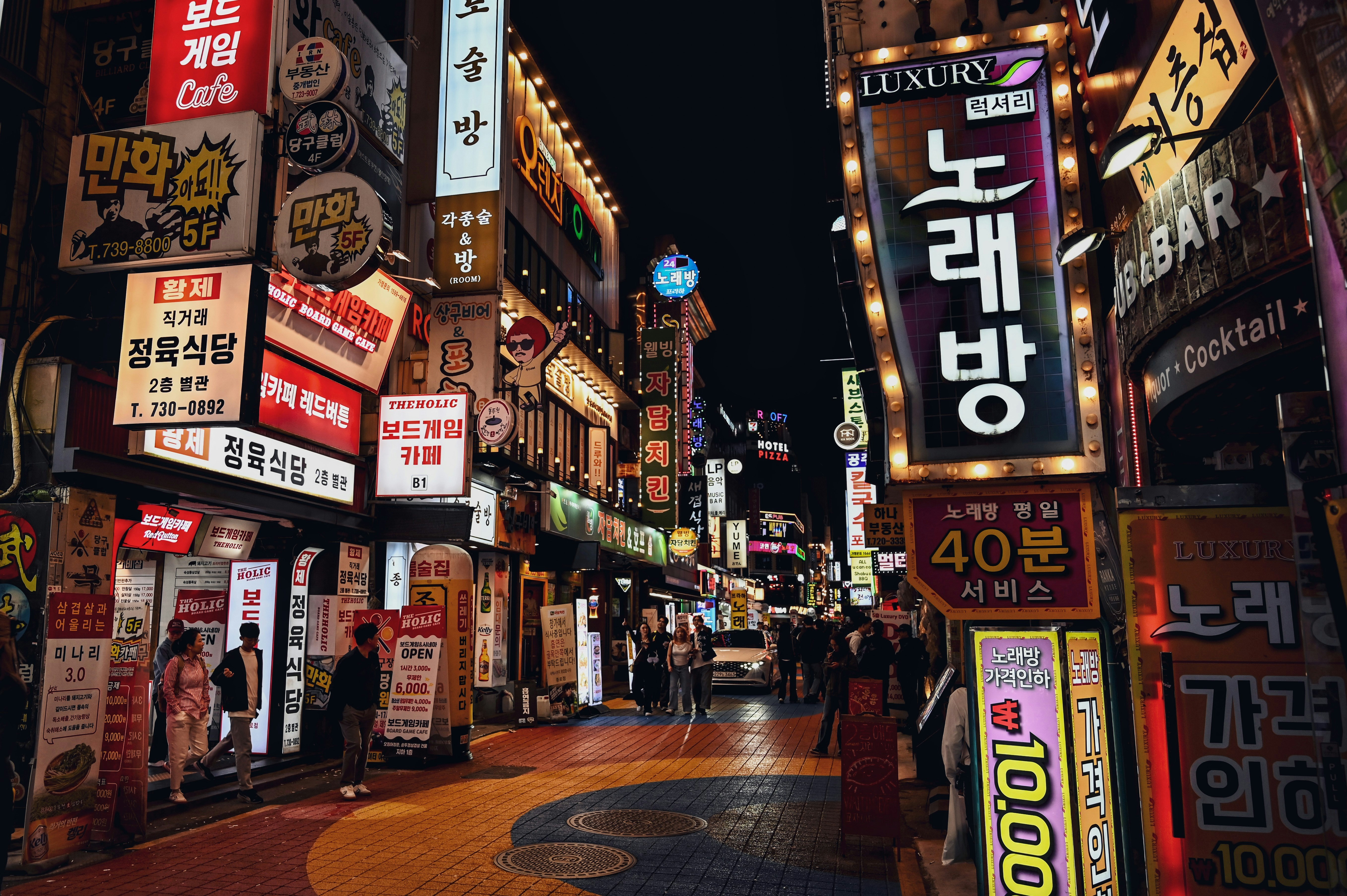 Neon lights illuminate a bustling street in korea. photo – Free Seoul ...